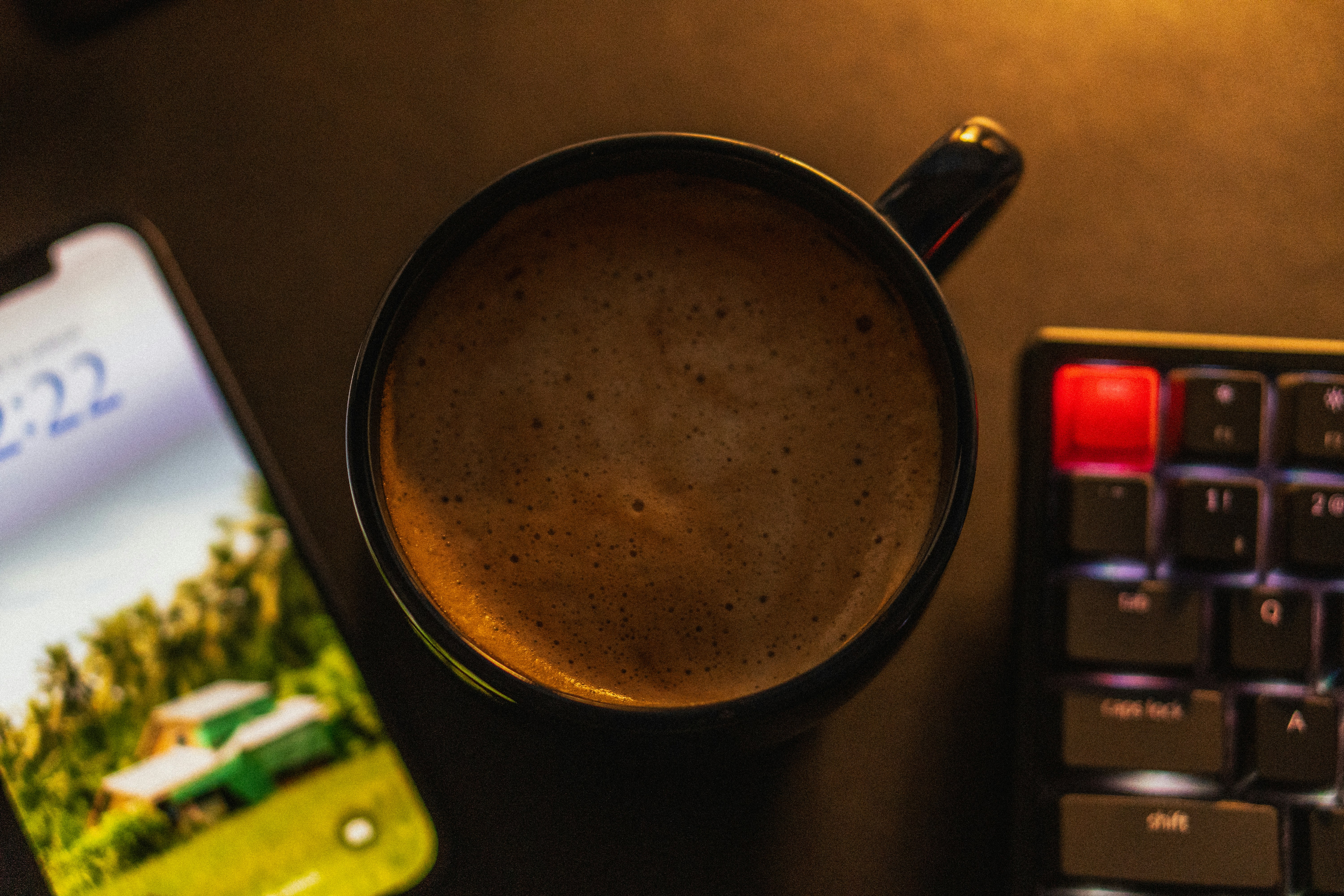 Center Cup, Quiet Desk: Steam Rising Over a Keyboard and Phone