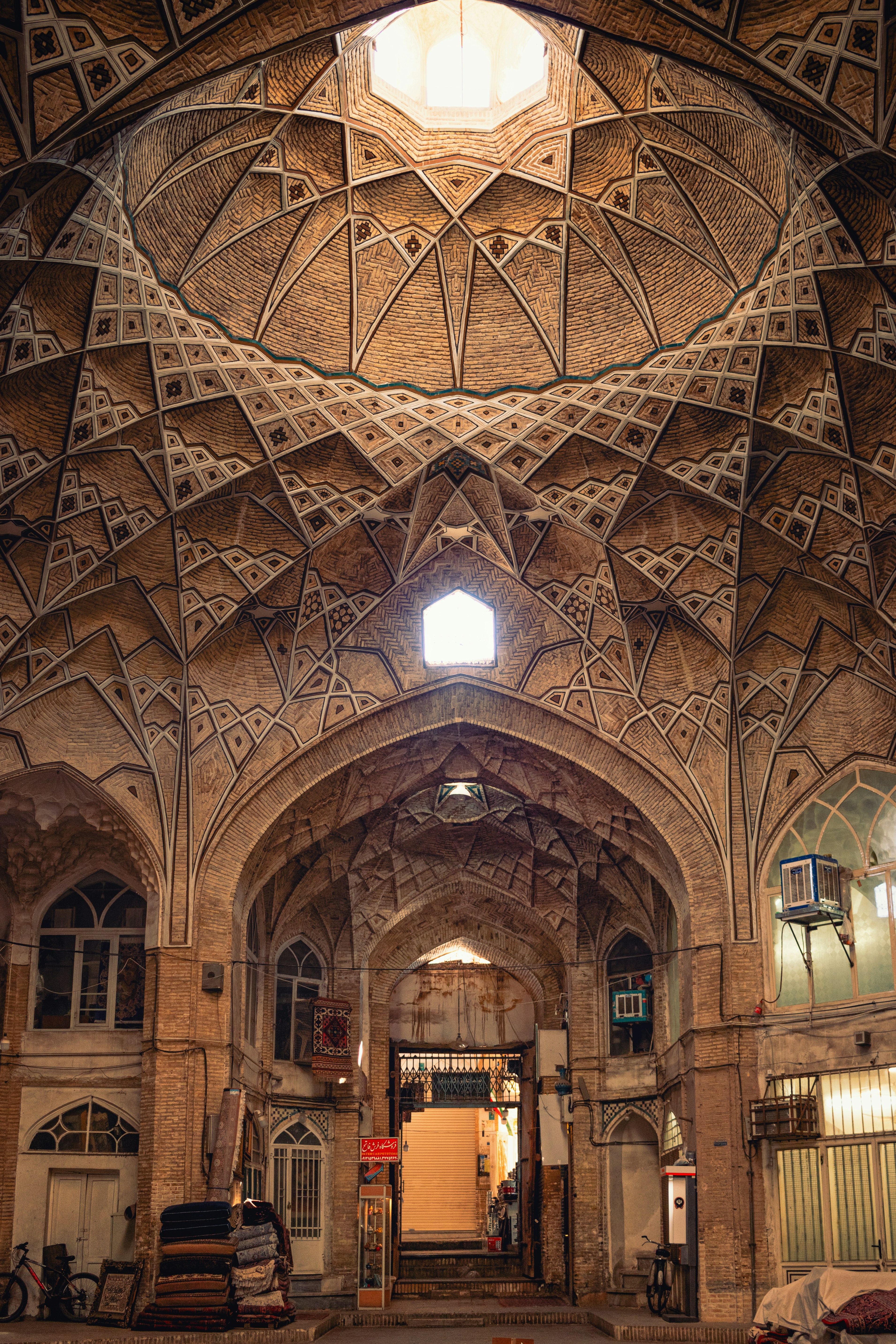 Geometric Vaults Converge on a Sunlit Doorway in a Brick Cathedral
