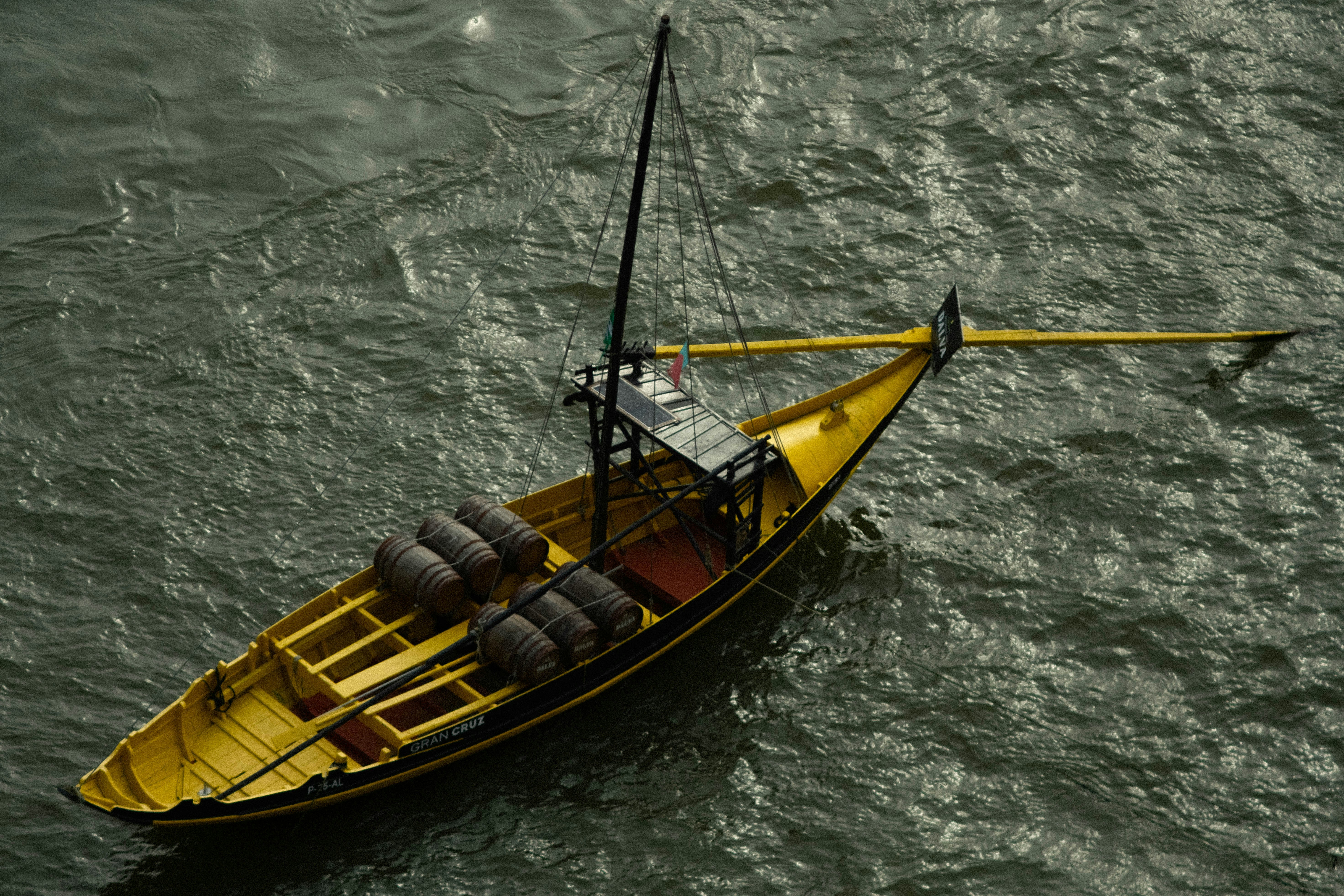 Yellow Barrels Afloat: Aerial Portrait of a Compact Cargo Boat