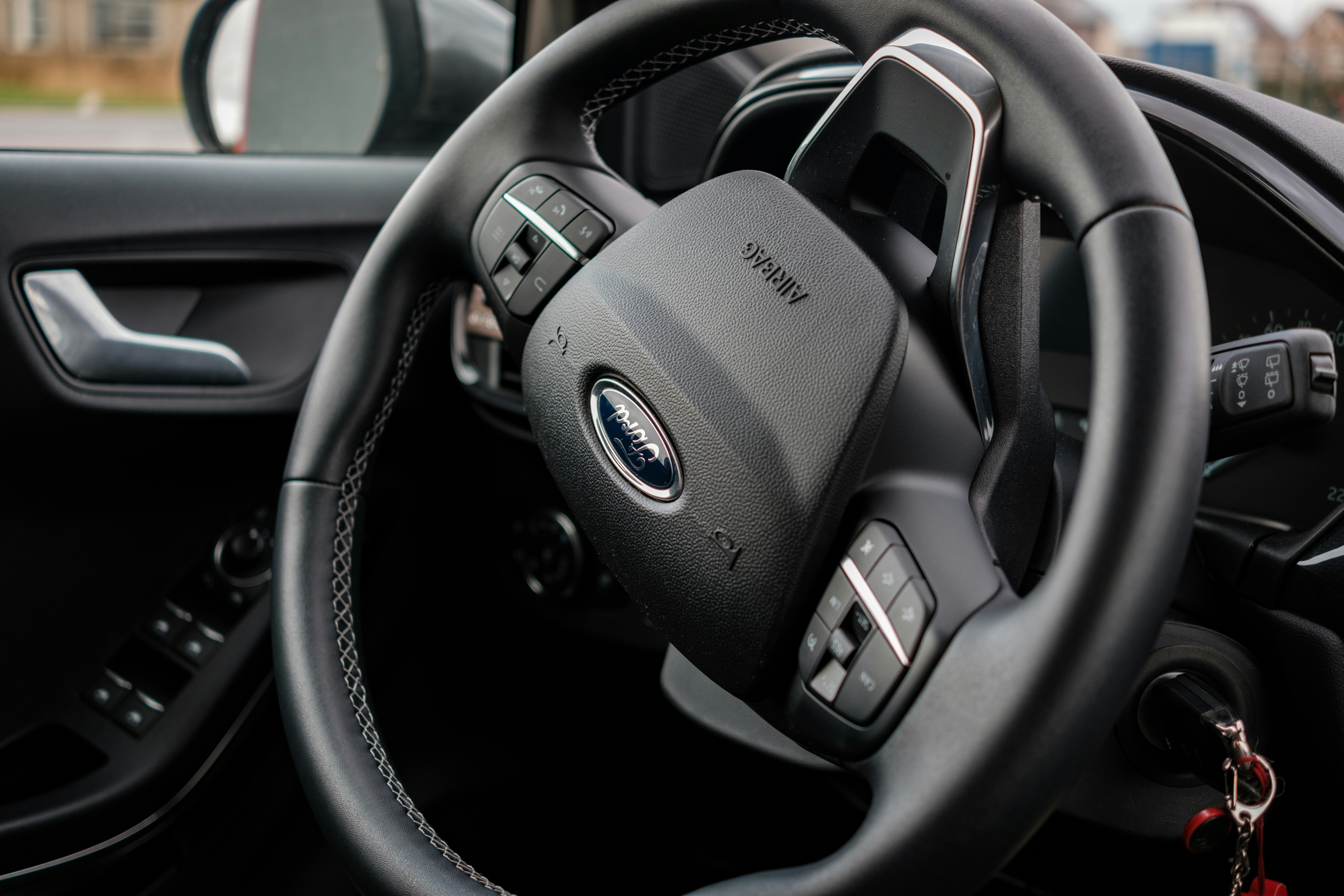 Foto zum Thema Das Lenkrad eines Autos mit schwarzem Armaturenbrett ...