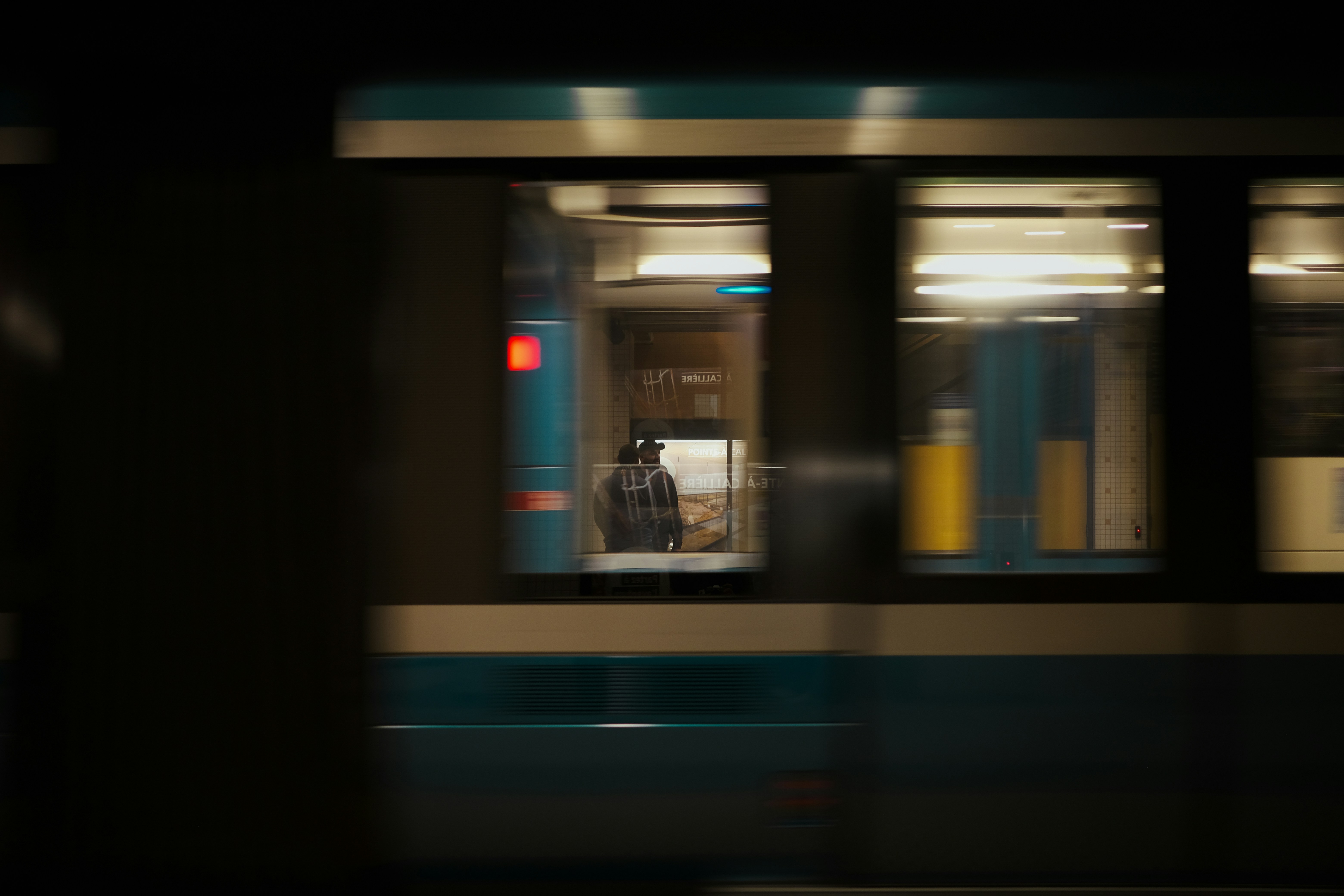 Mid-Transit Silhouette: A Solitary Commuter in Teal Railcar