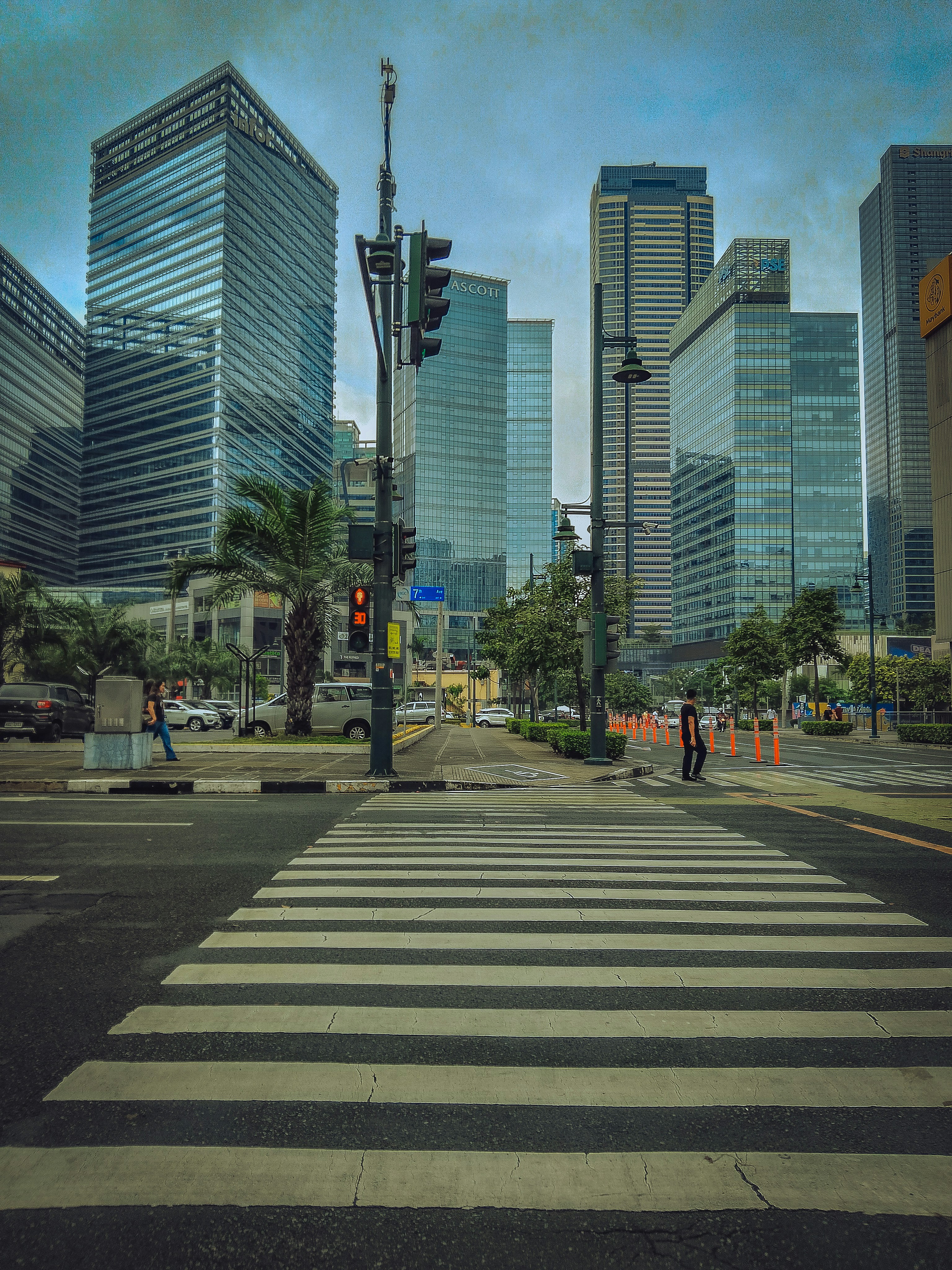 A crosswalk in a city with tall buildings in the background photo ...