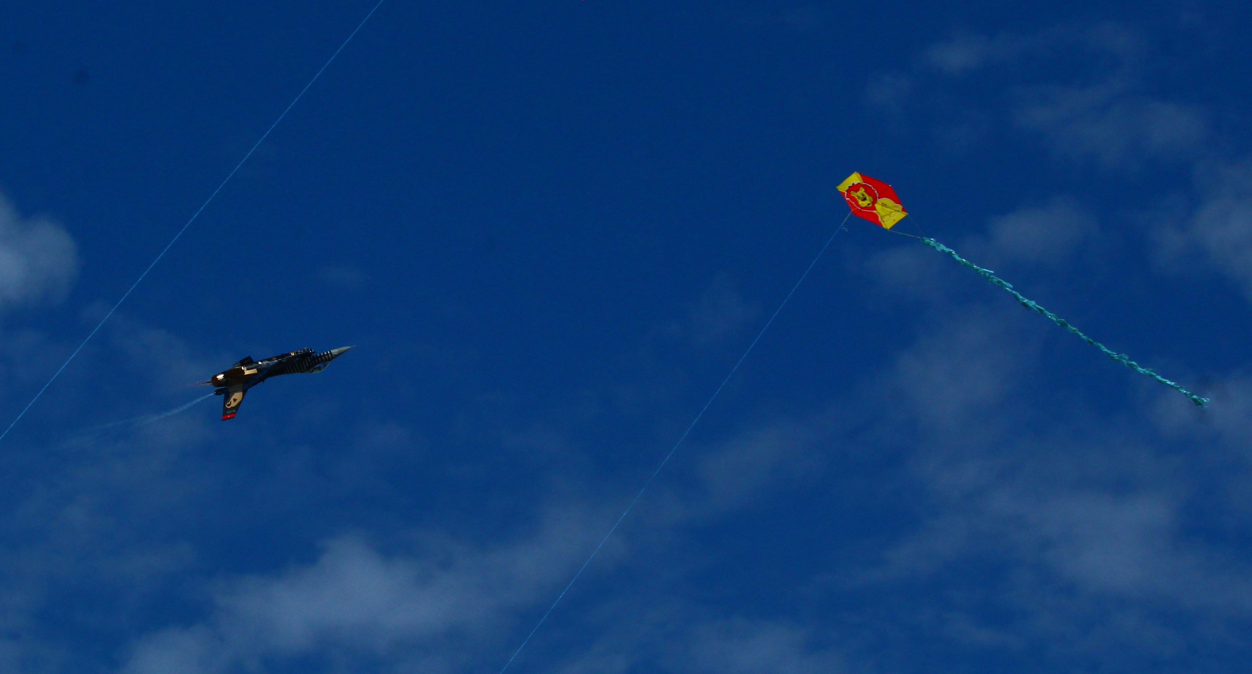 Red Diamond Kite Slices Across a Cobalt Sky with a Green Tail