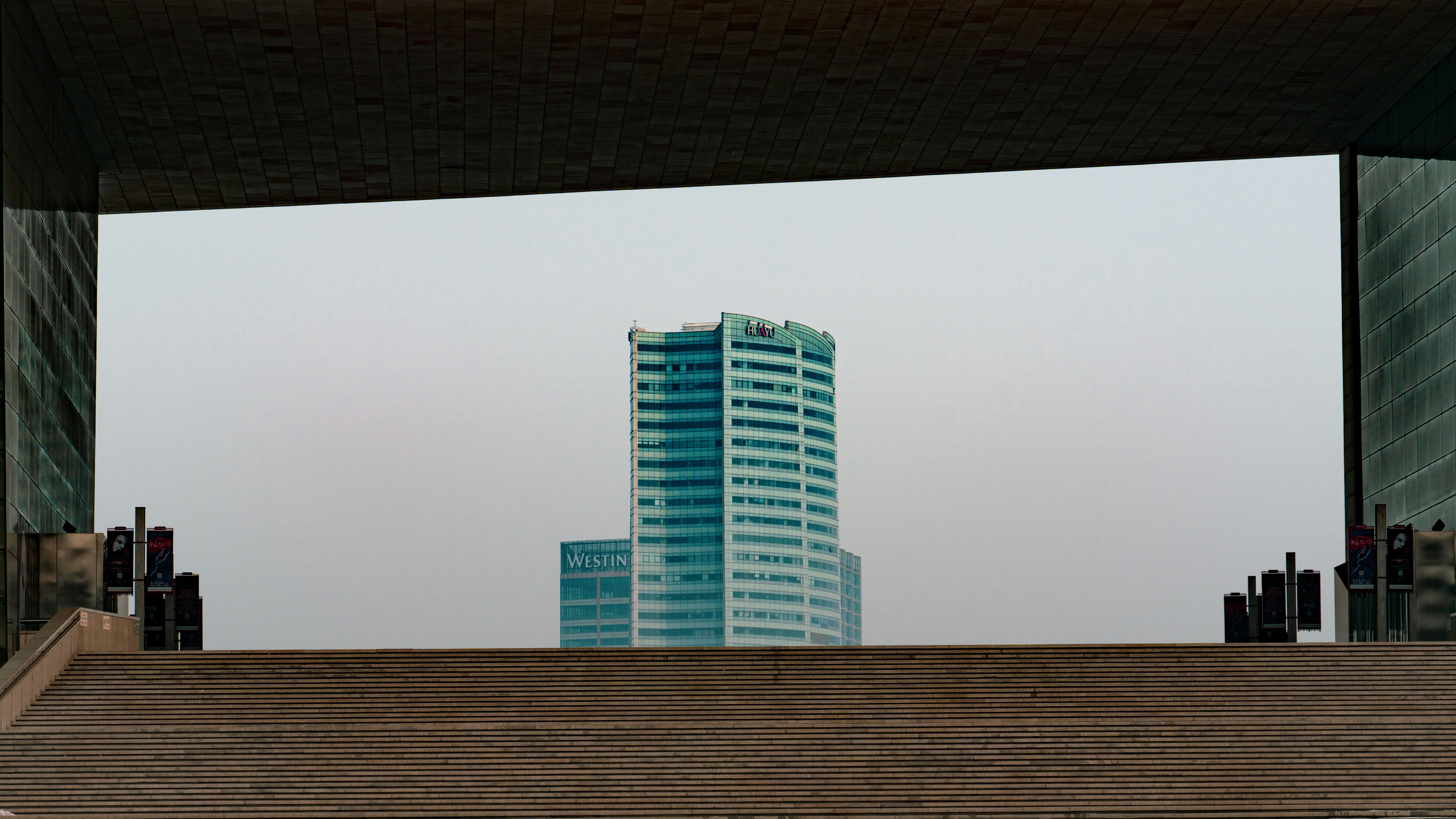 Blue Glass Sentinel Framed by Concrete Arches