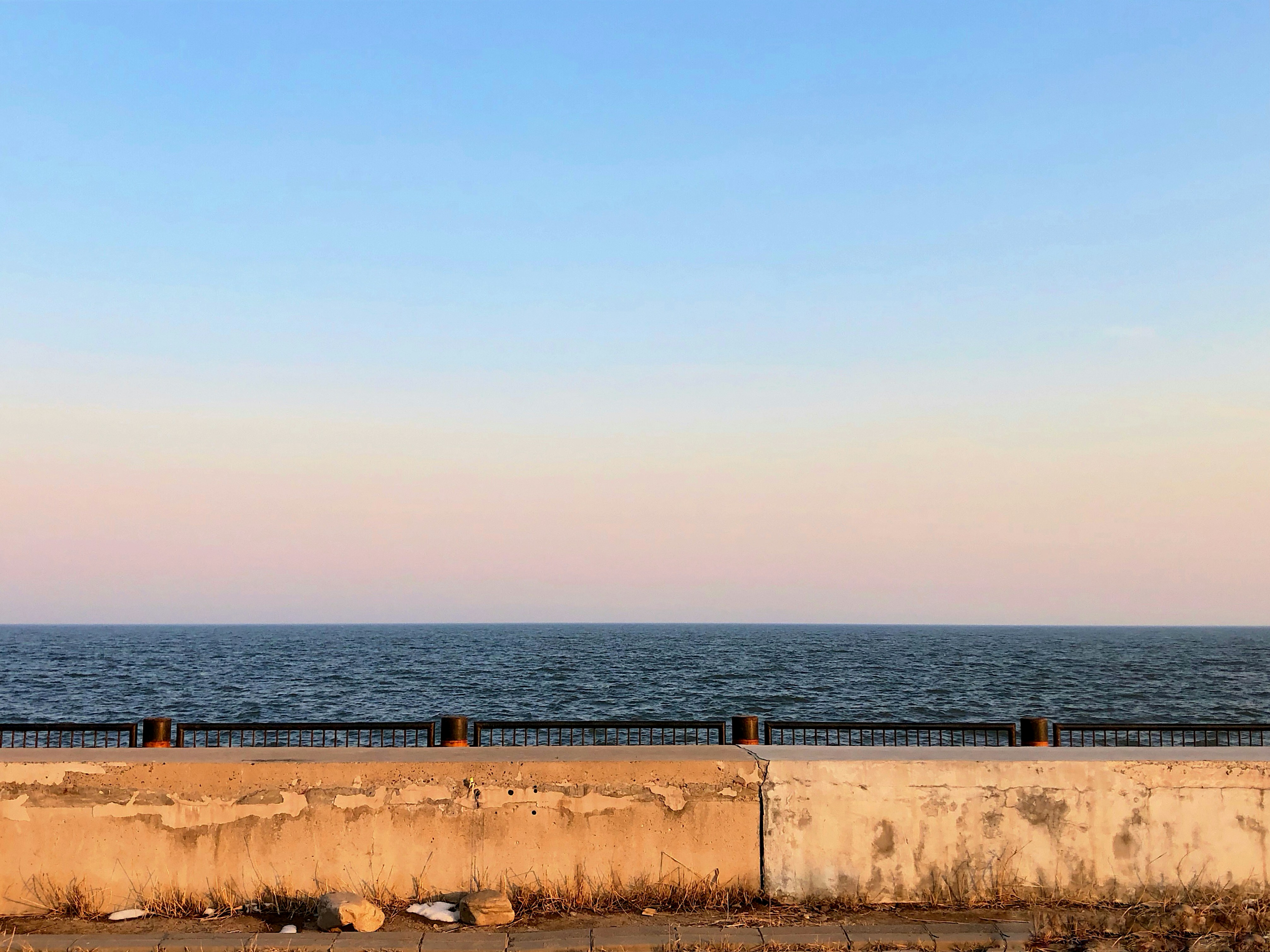 Pastel Horizon Over a Weathered Seawall