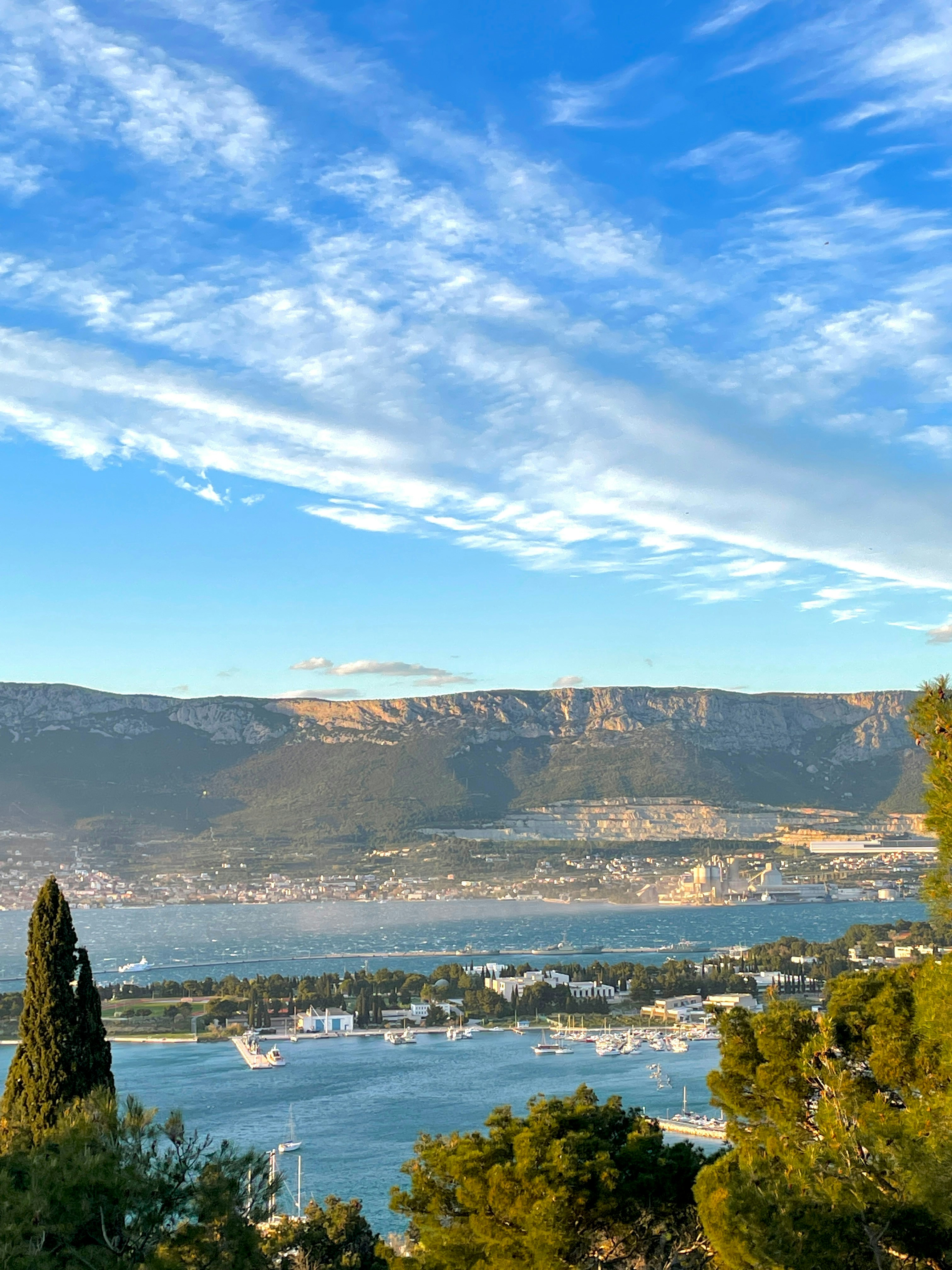 a scenic view of a bay and mountains in the distance