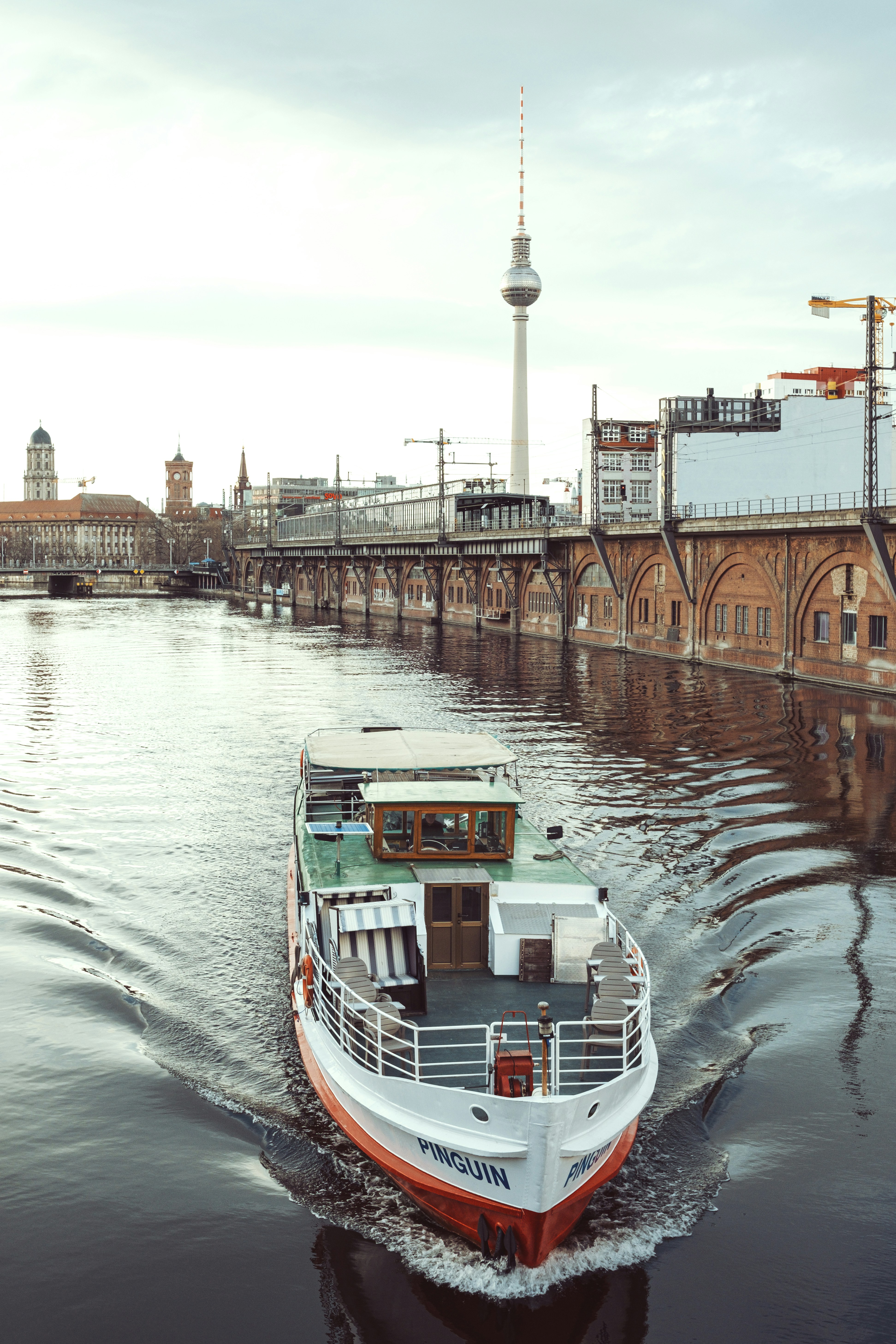 Crimson Bow on the Spree: A Riverboat Glide Beneath Berlin’s Brick Arches