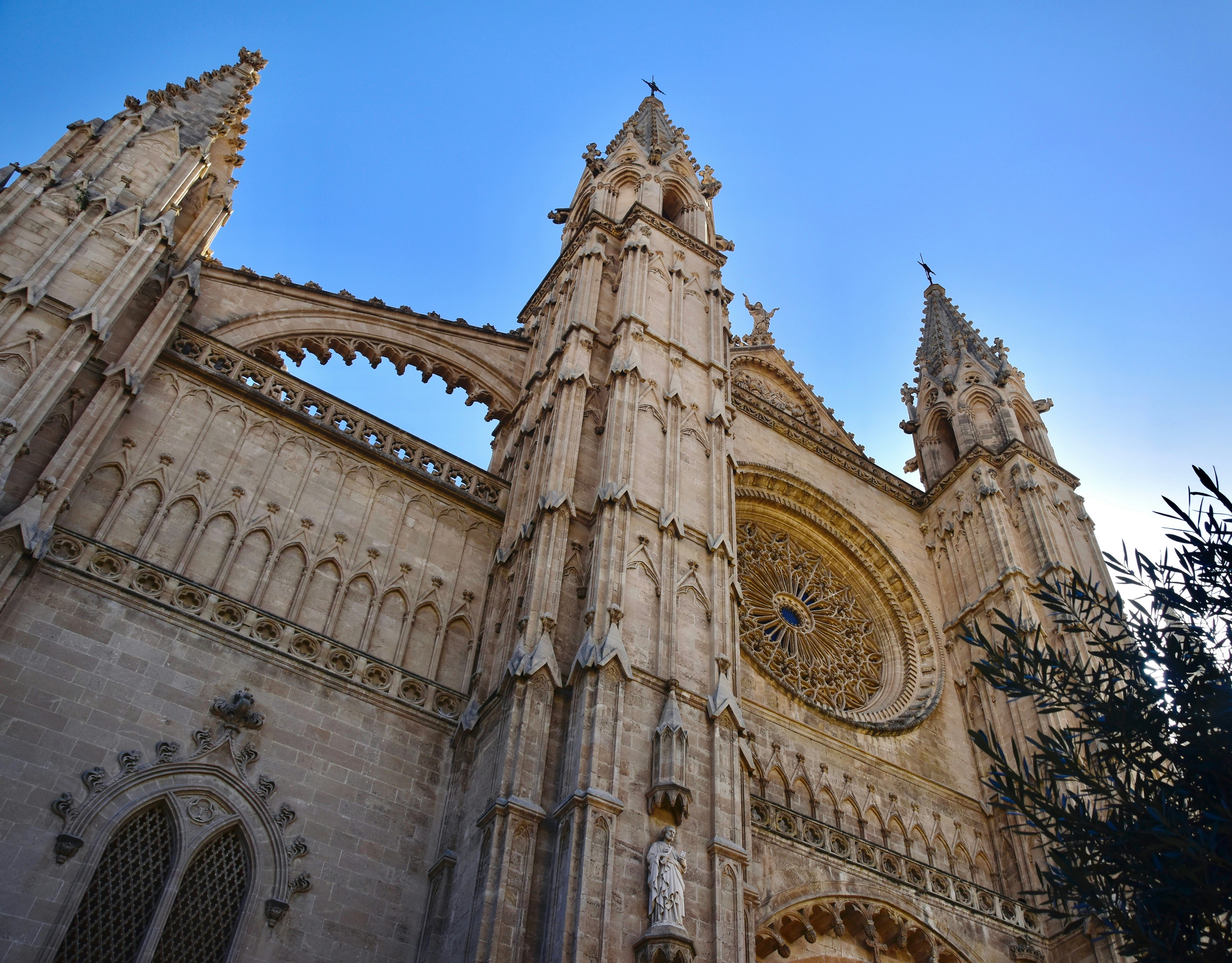 Ornate Gothic cathedral facade with intricate stonework against a clear blue sky.