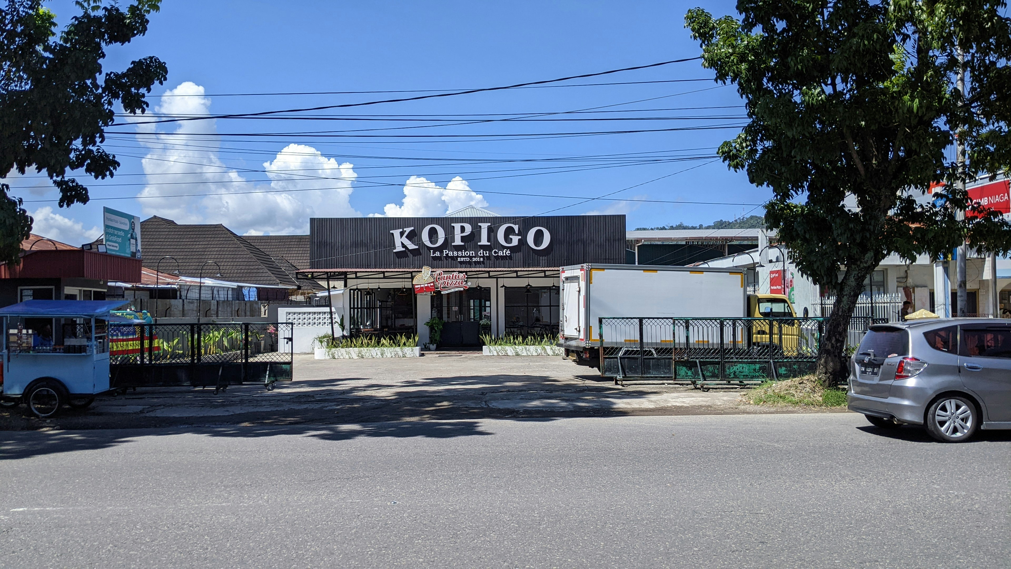 Foto Vista de la calle de un restaurante kopigo con coches aparcados ...