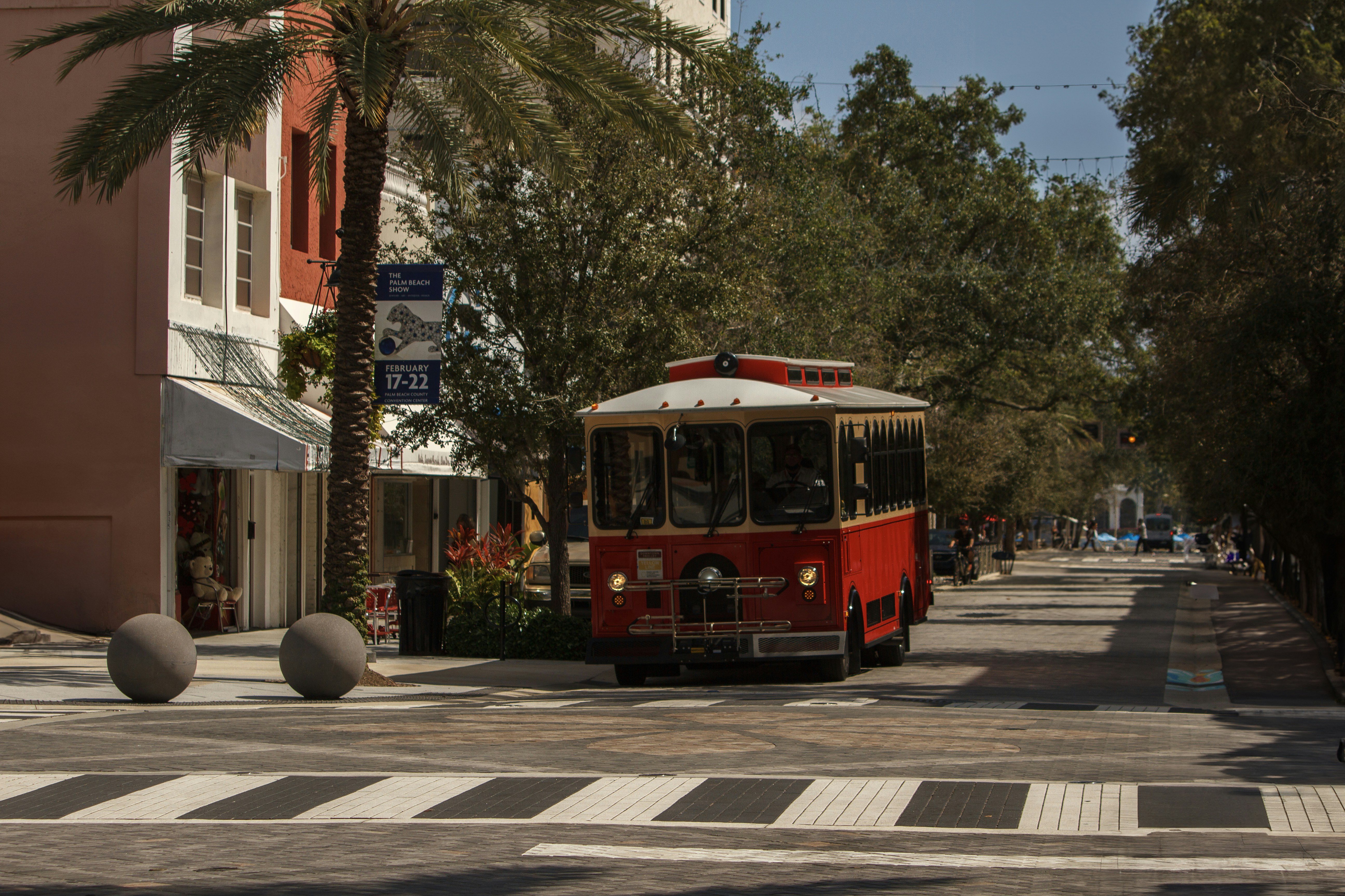 A red bus driving down a street next to tall buildings photo – Free ...