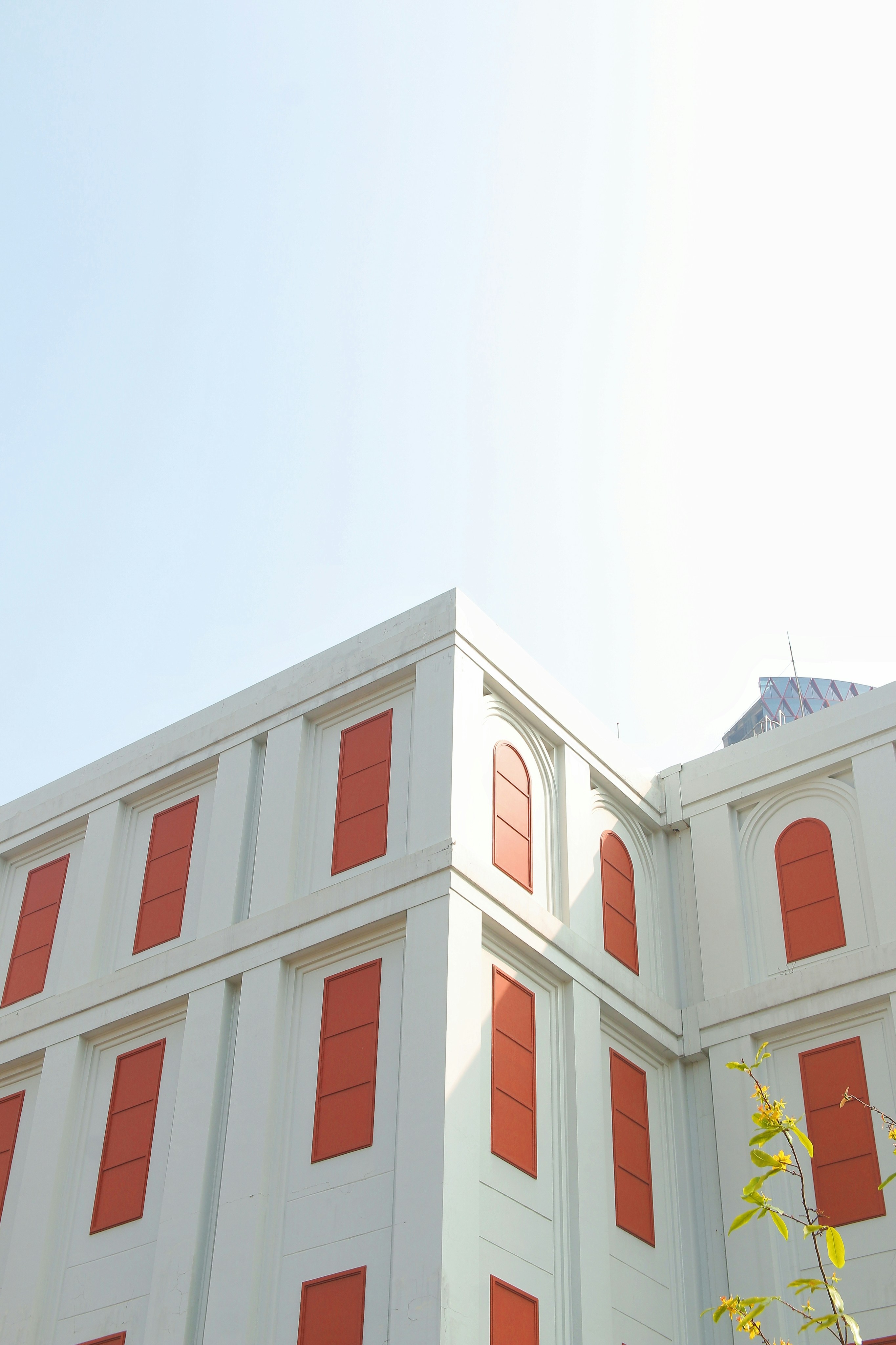 A tall white building with orange windows and a clock photo – Free ...