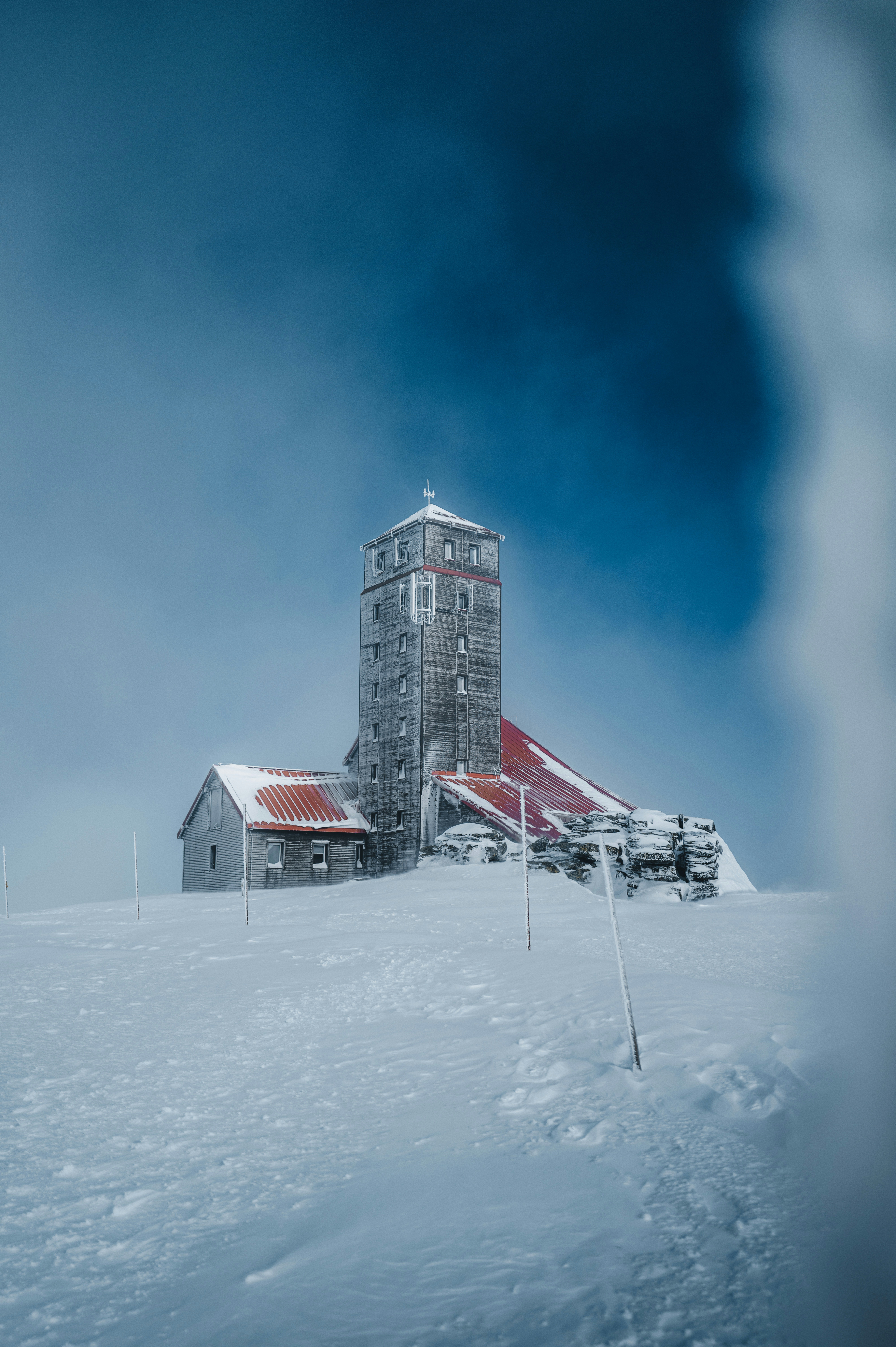 A tall building sitting on top of a snow covered slope photo – Free ...