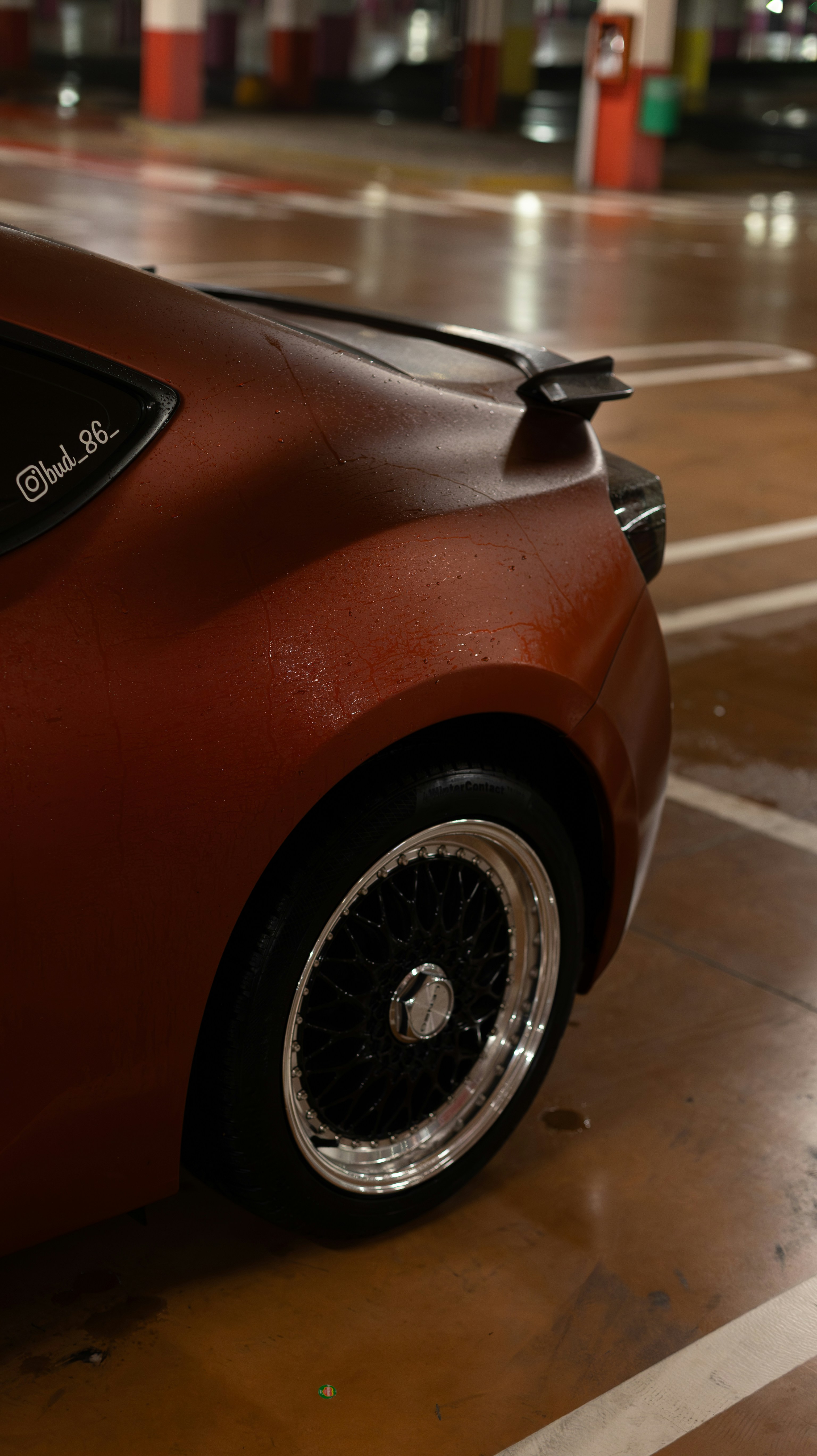 Copper-Brown Curves: Wheel and Rear Quarter in a Moody Garage