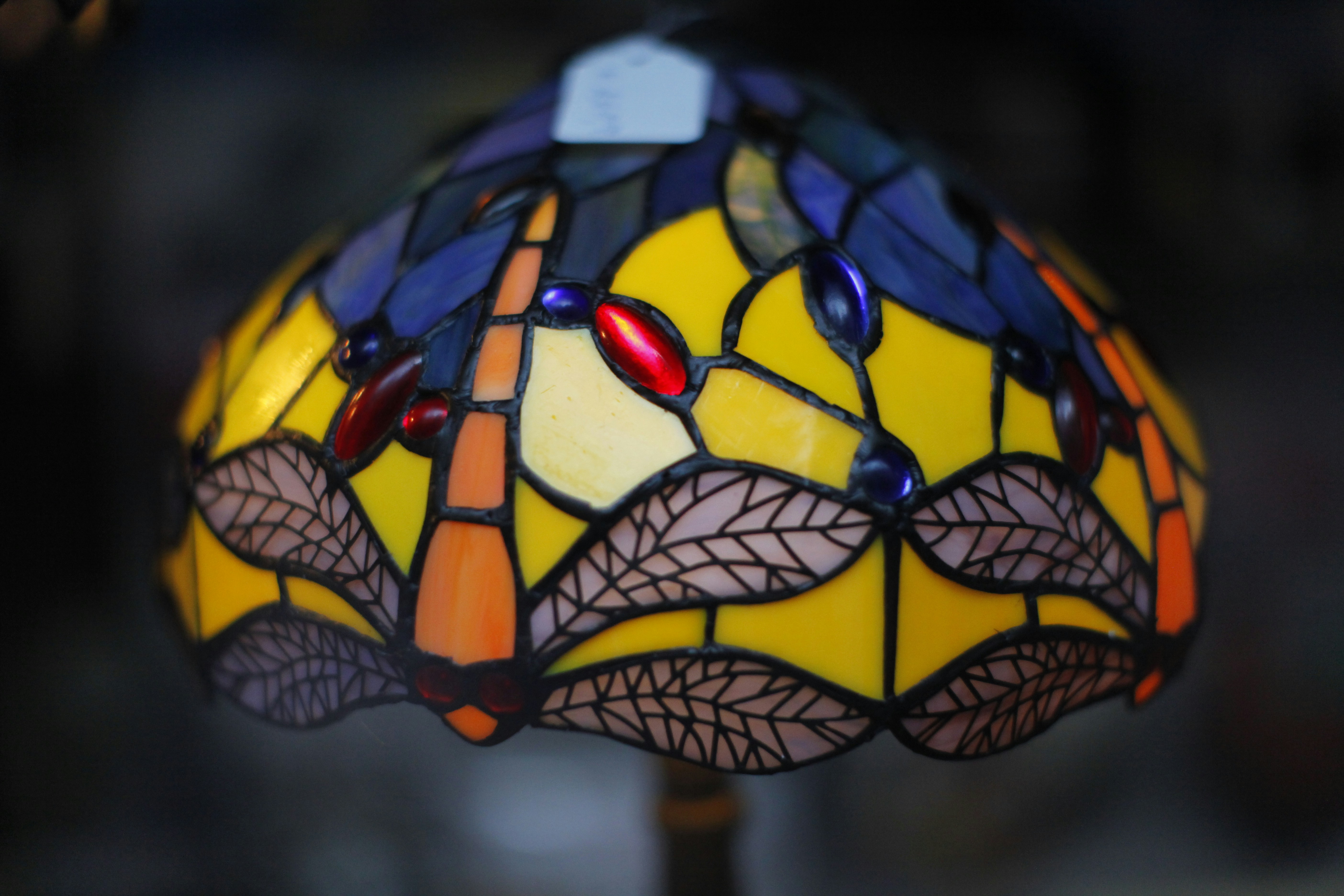 Luminous Mosaic: Close-Up of a Tiffany-Style Lamp's Yellow Petal Glass and Ruby Center