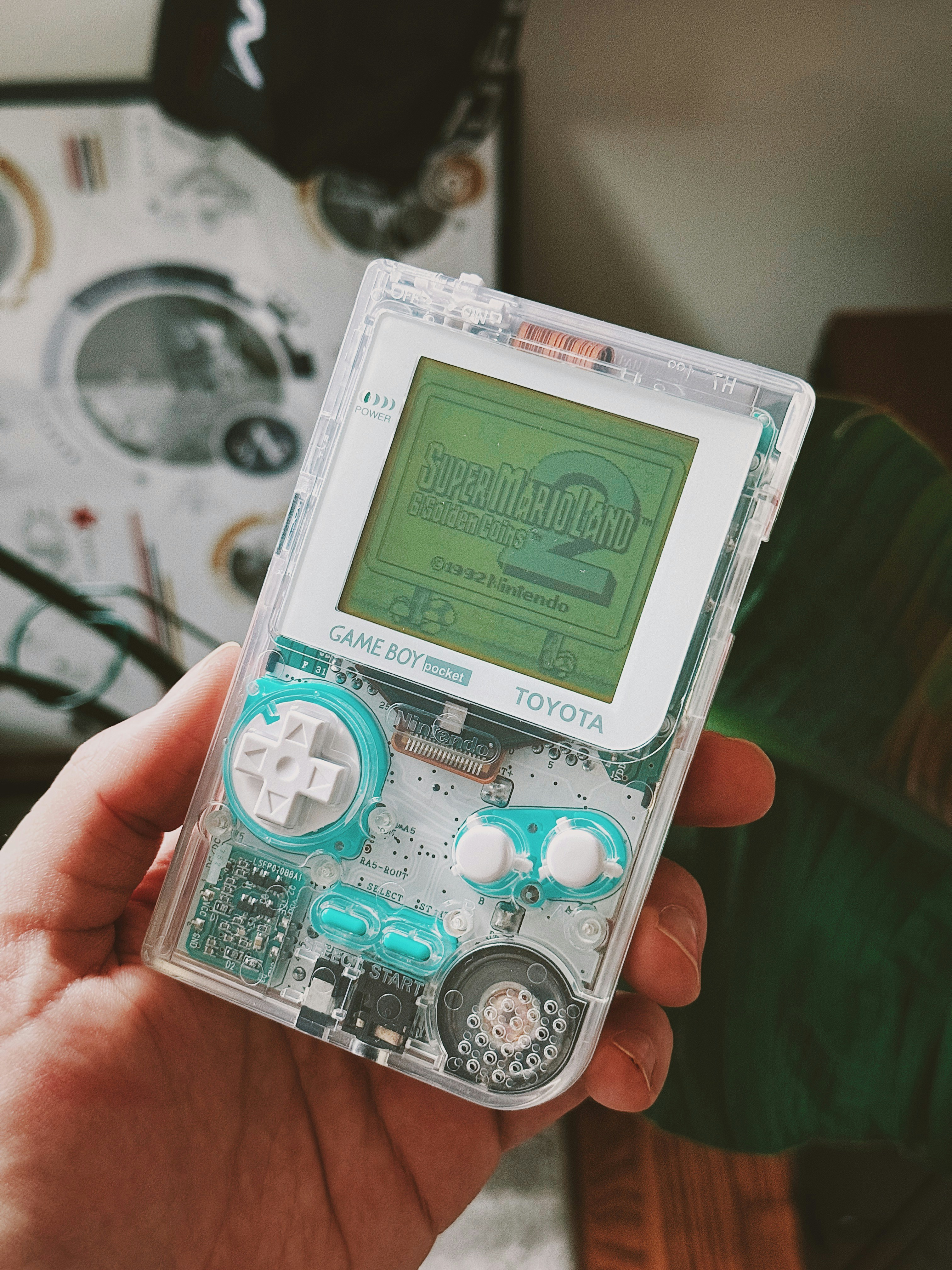 A person holding a gameboy in their hand photo – Free Office Image on ...