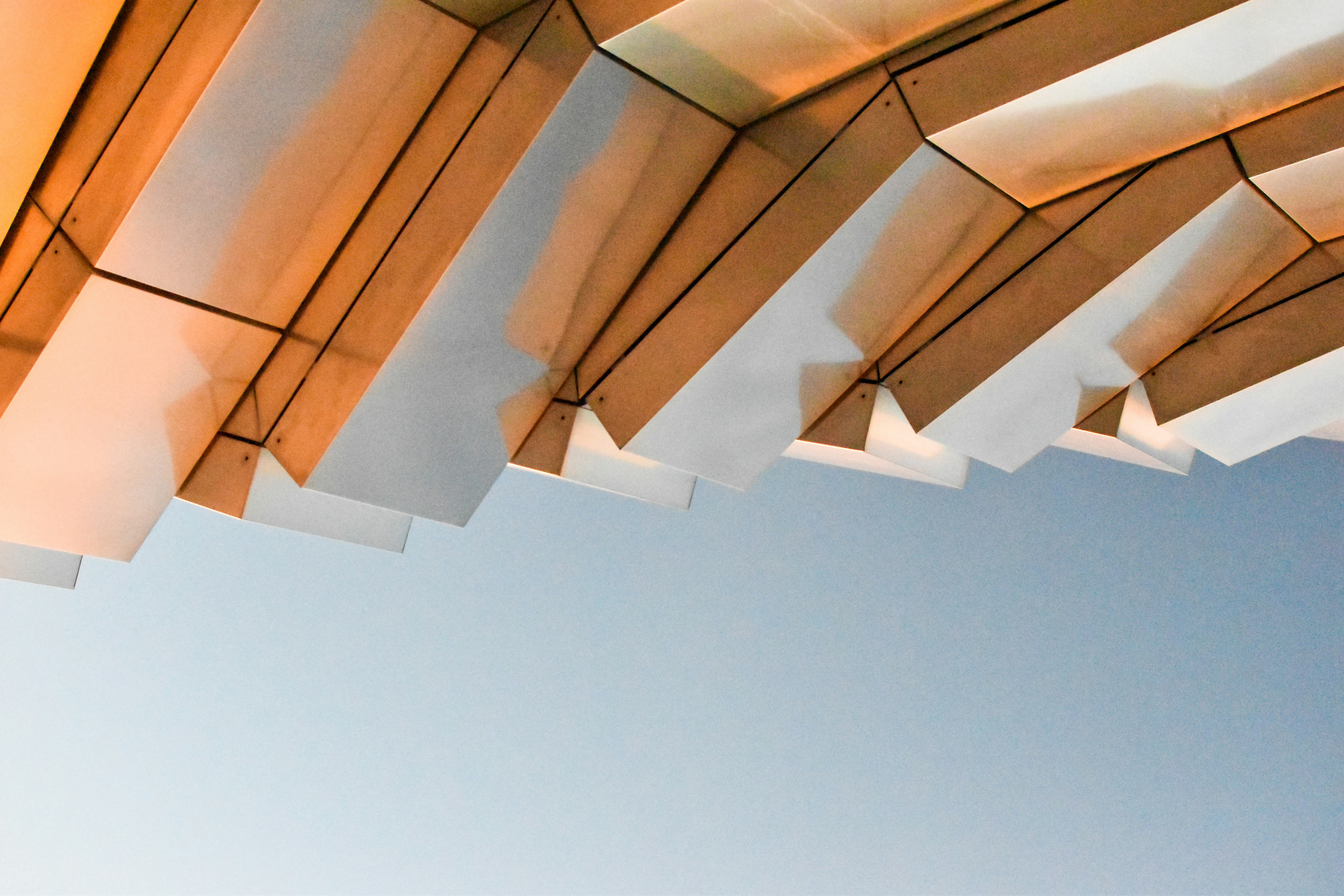 Close-up of an umbrella's angular design set against a clear blue sky.
