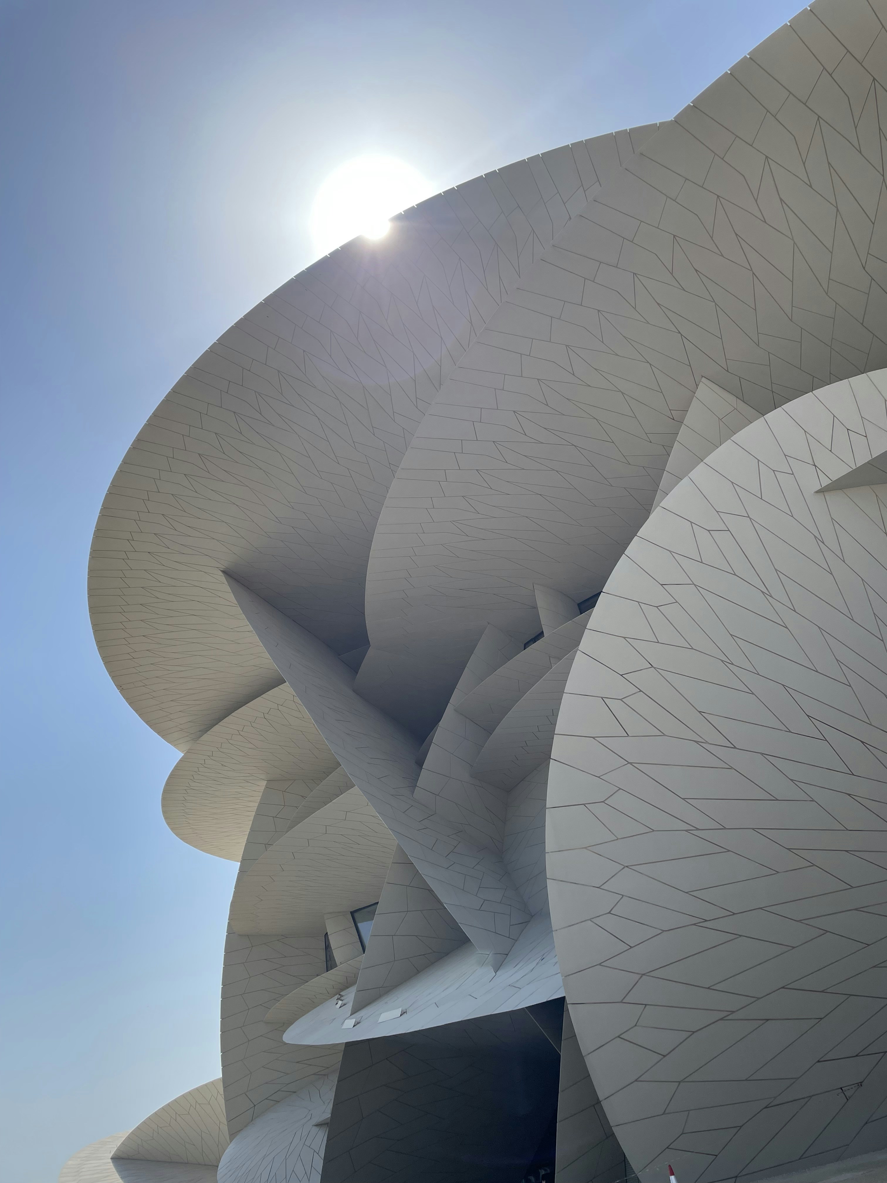 the exterior of a modern building with a sun in the background