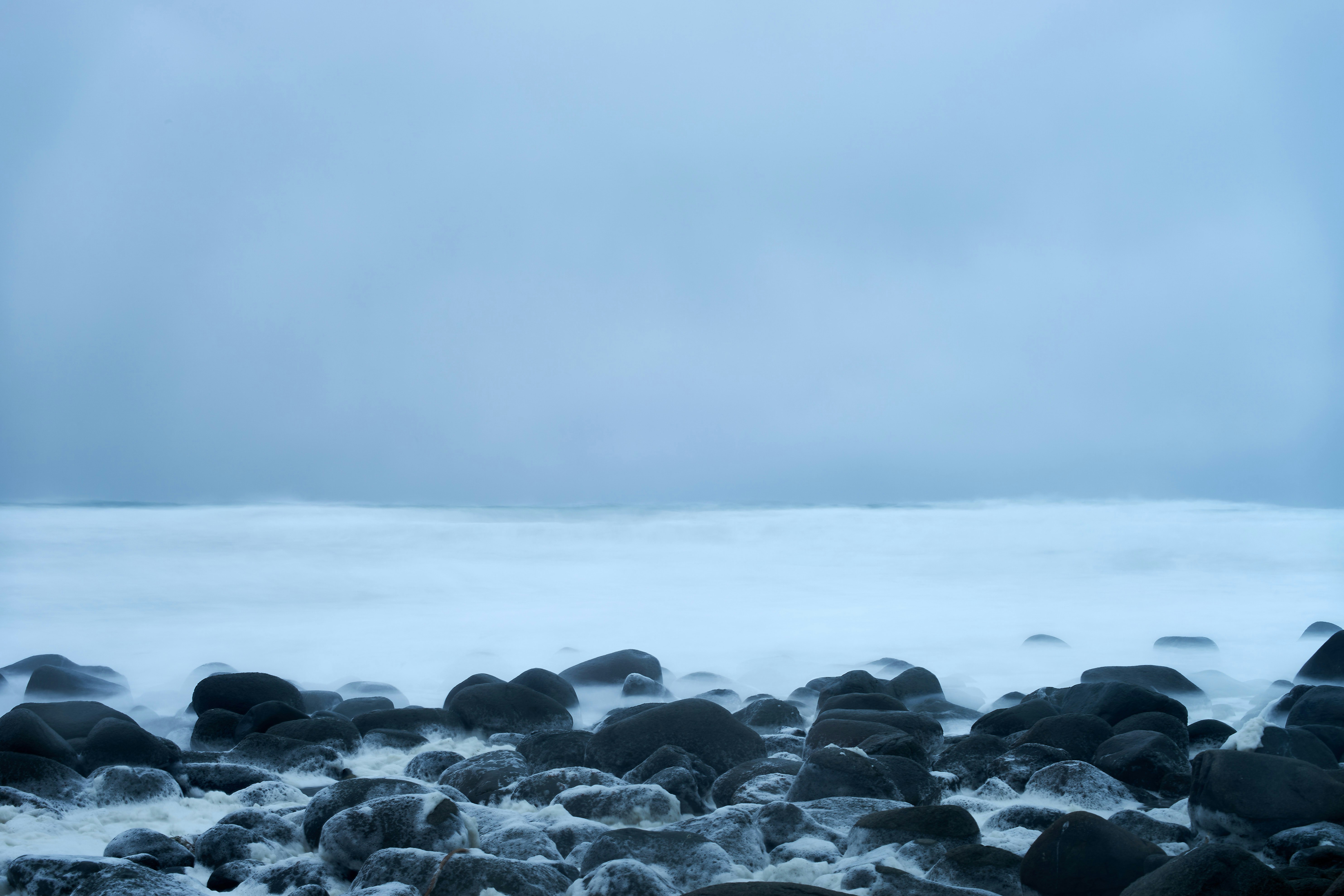 A large body of water surrounded by rocks photo – Free Grey Image on ...