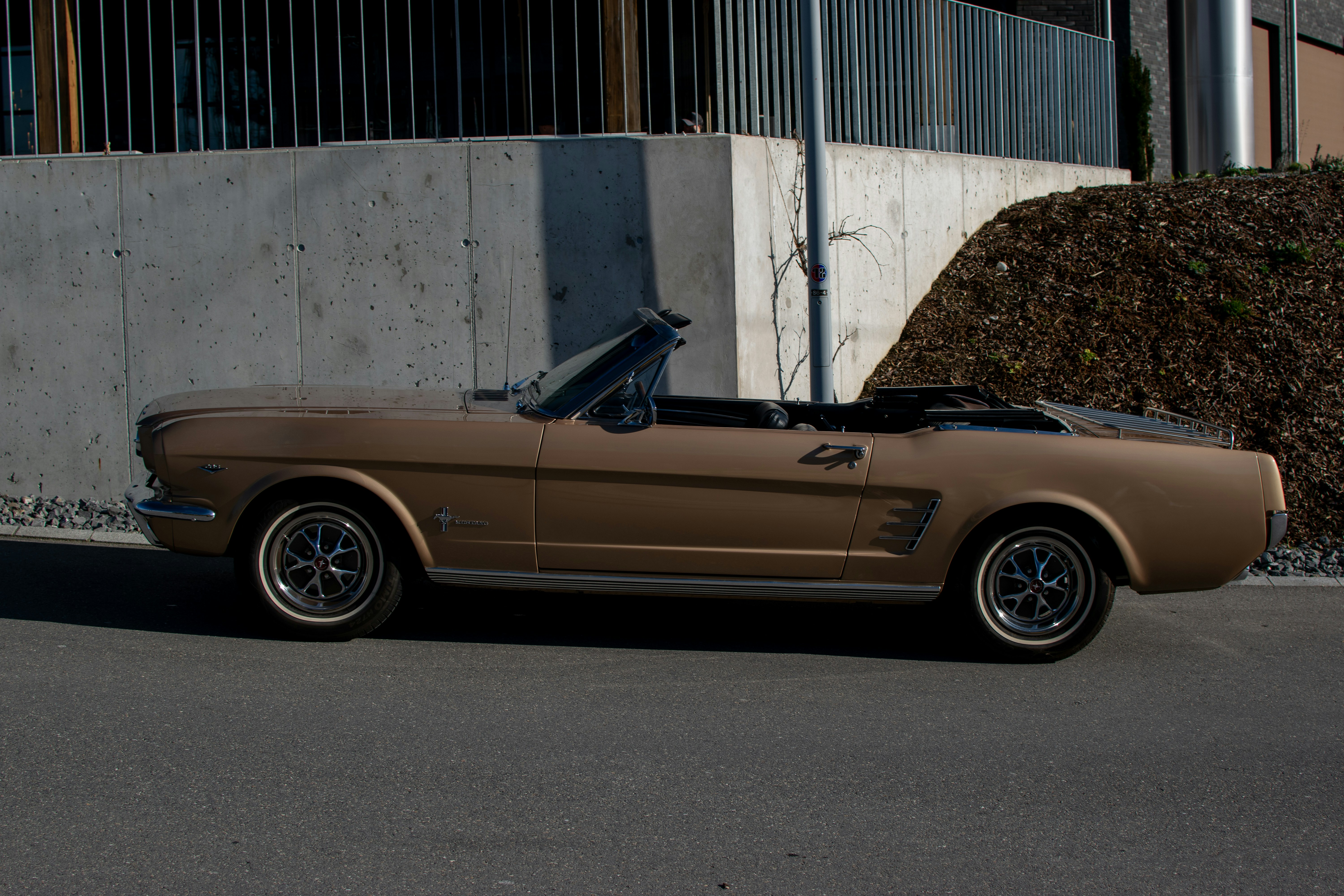 A brown mustang convertible parked in front of a building photo – Free ...