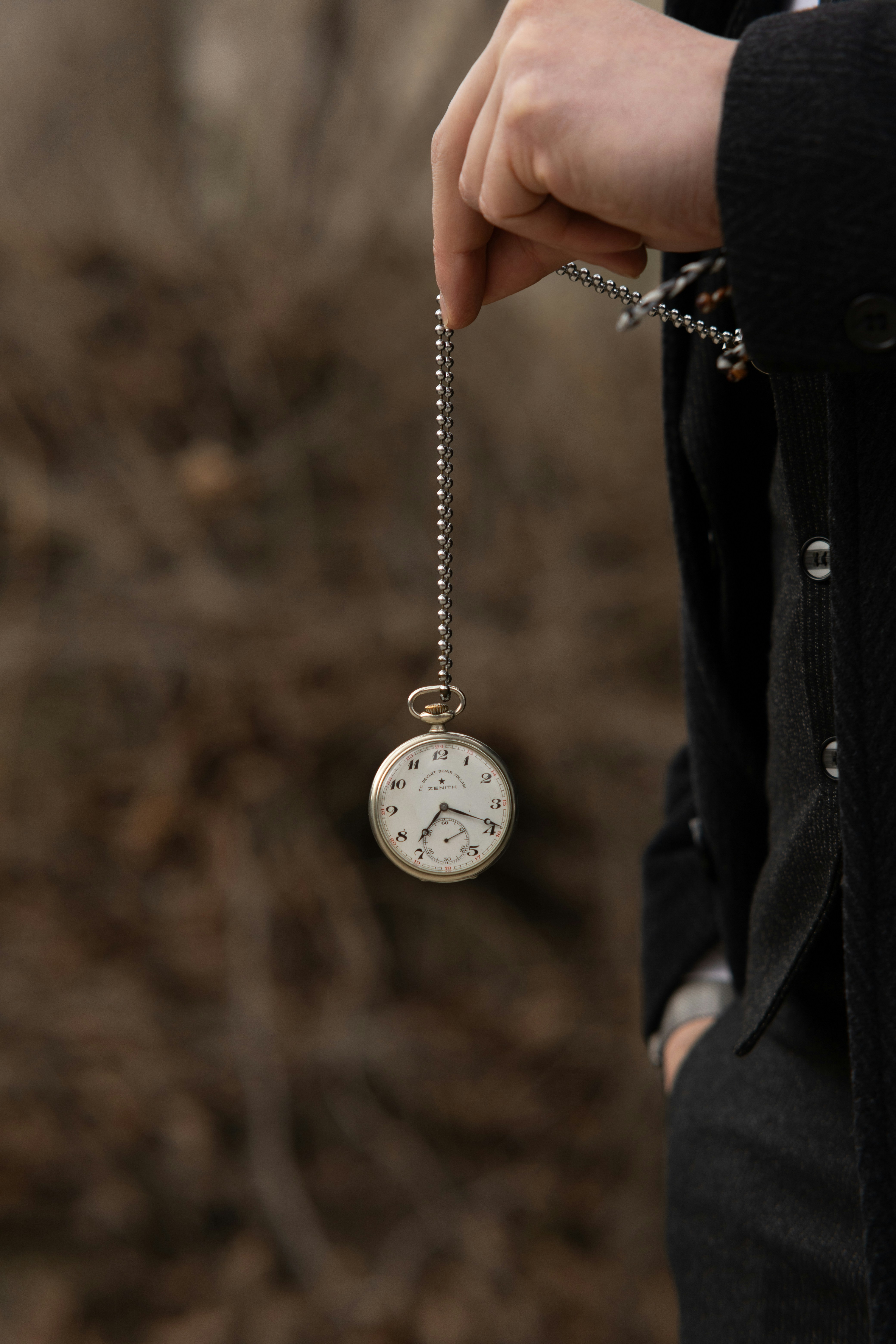 A person holding a small pocket watch on a chain photo – Free Grey ...