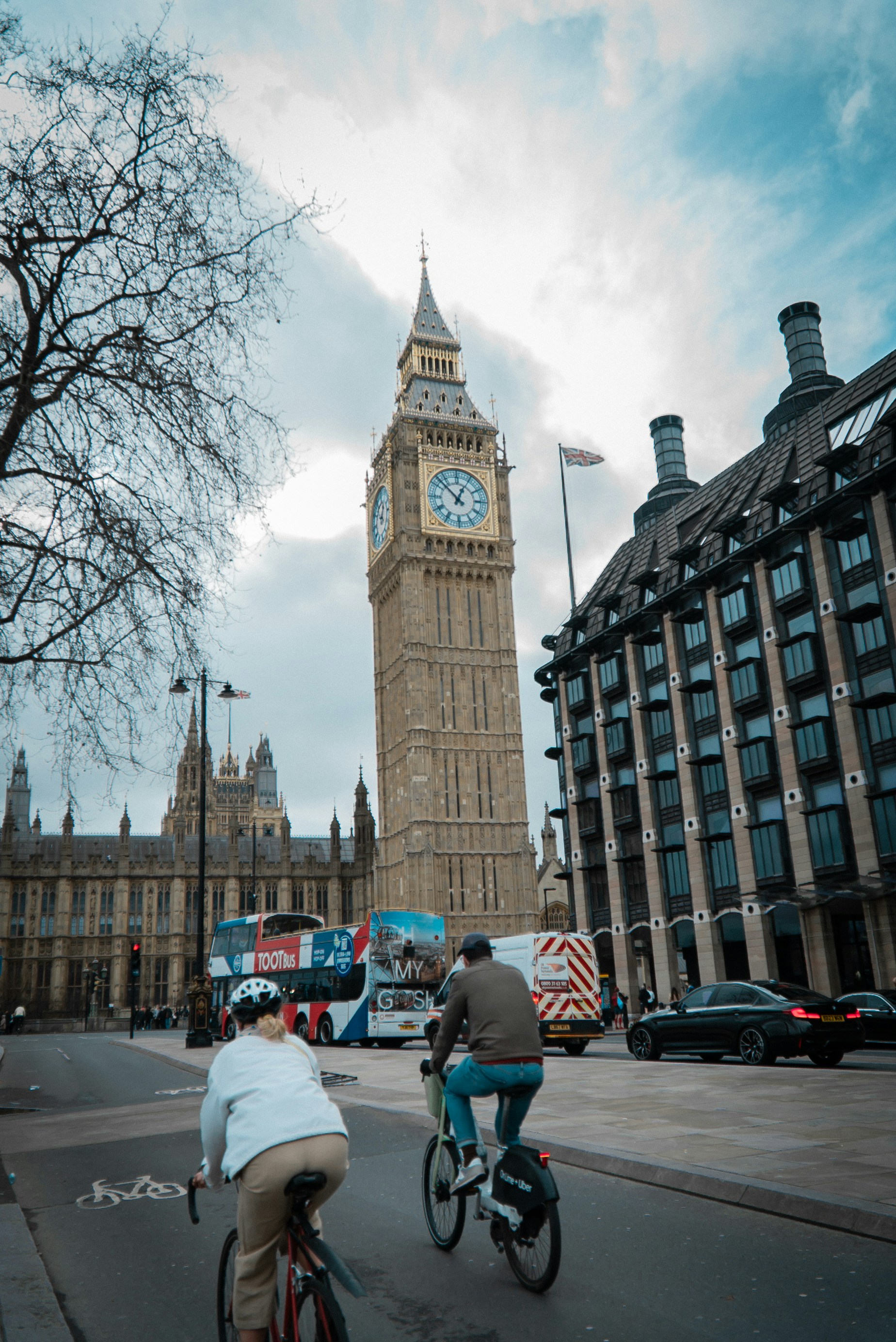 Westminster Pulse: Cyclists and the Clock Tower in a Lively London Street