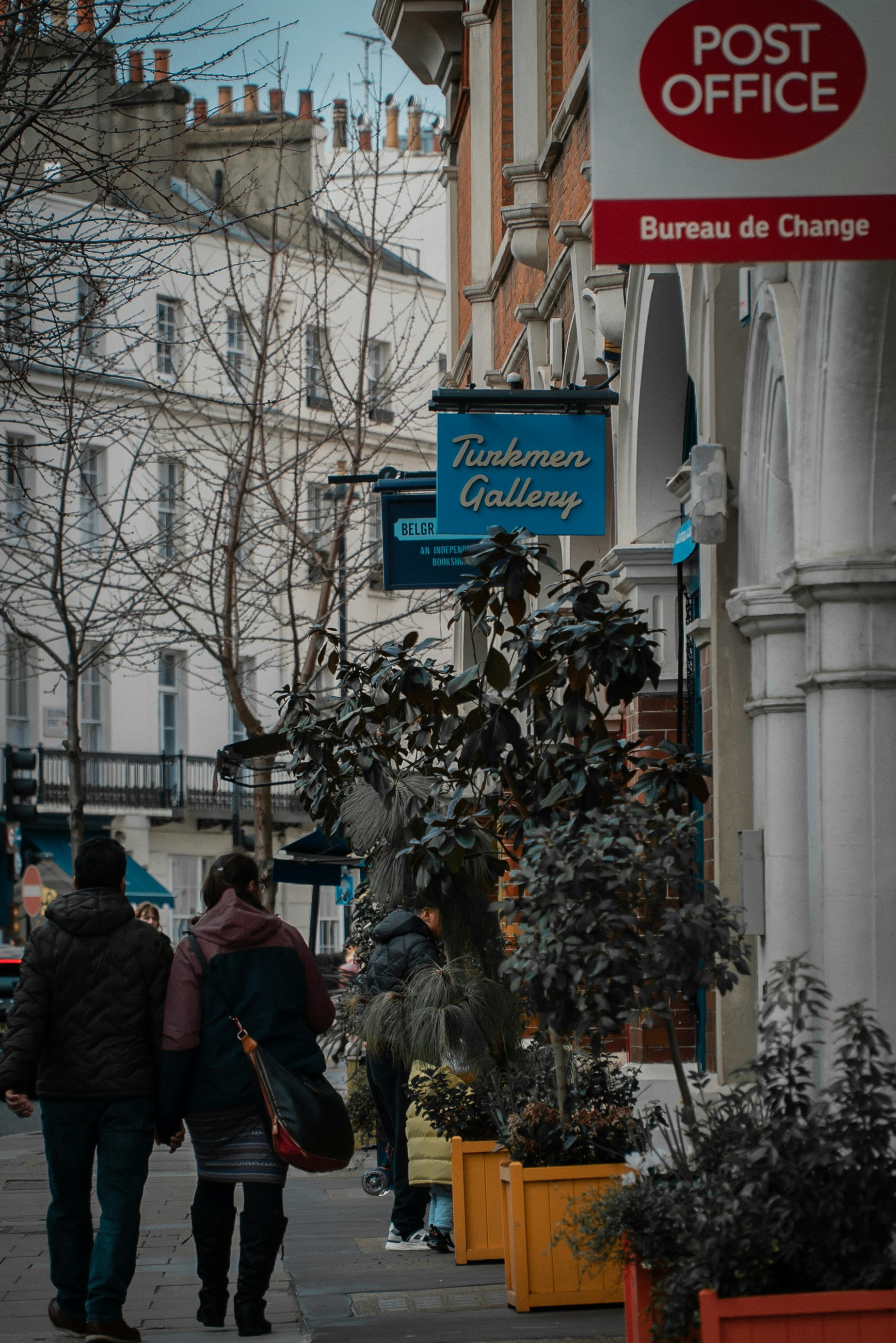 Blue Gallery Sign Among Pedestrians: A Street-Corner Moment