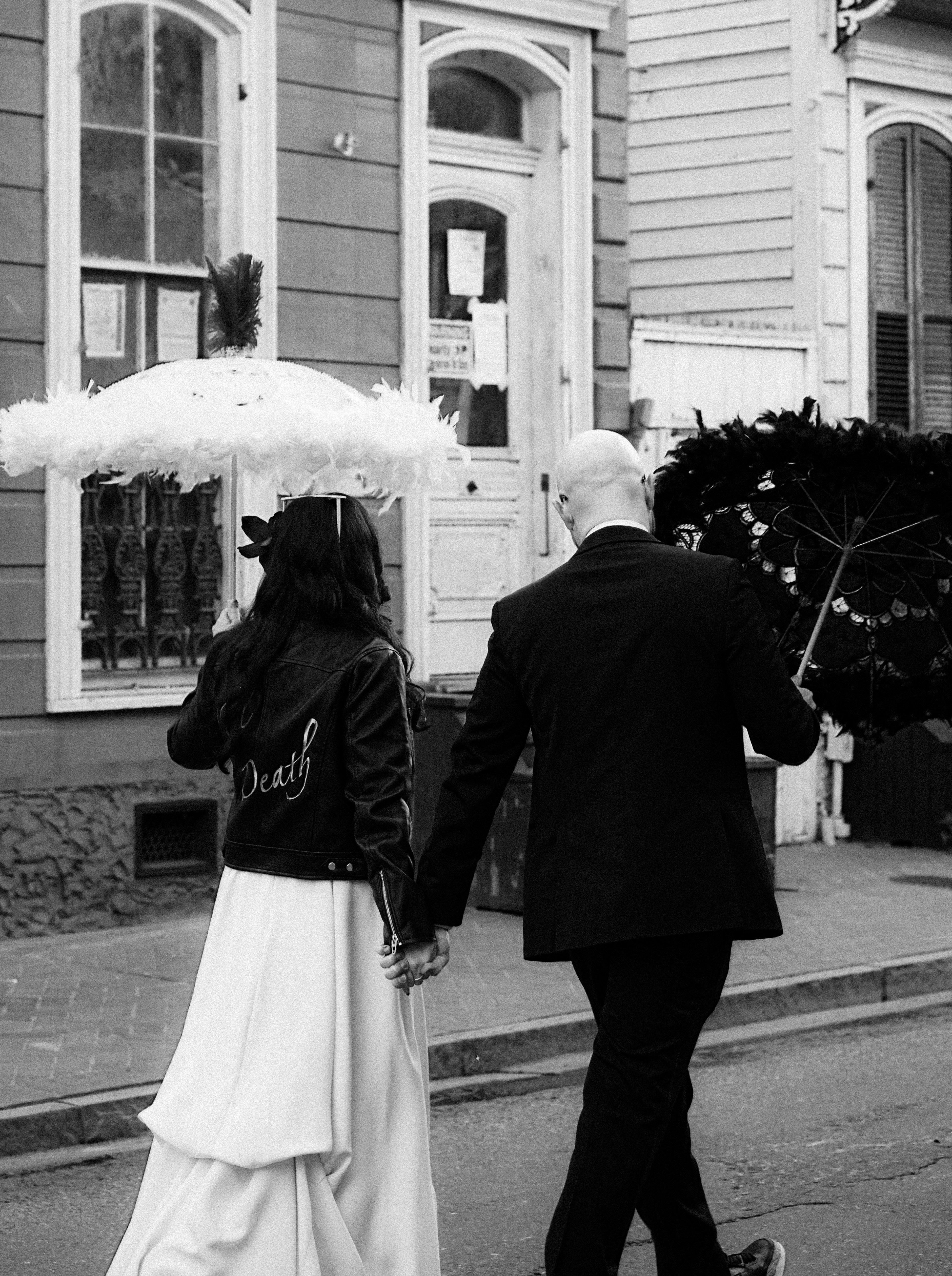 White Dress, Death Jacket: A Quiet Walk Beneath Umbrellas