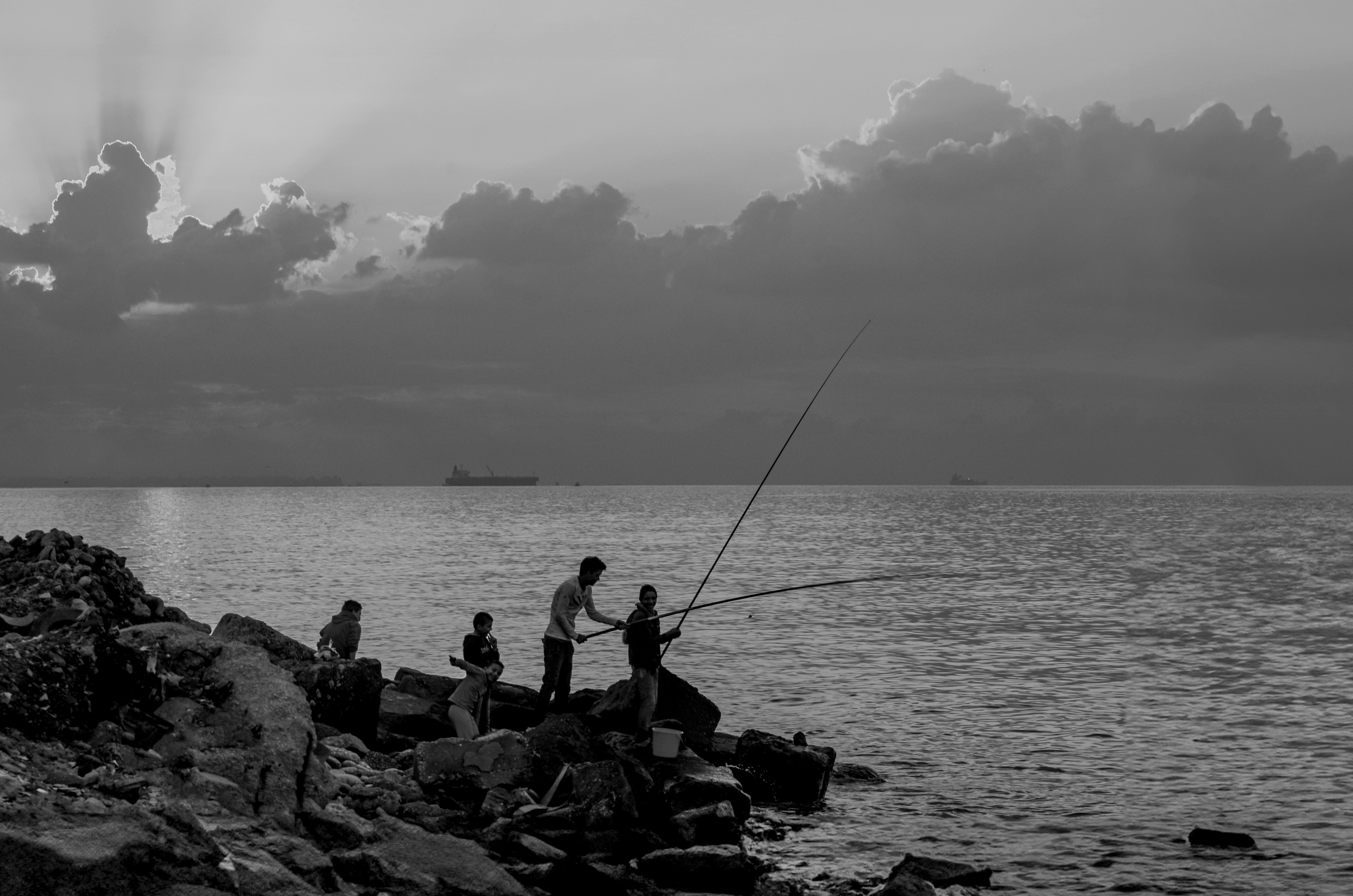 A group of people standing on top of a rocky shore photo – Free Nahr el ...