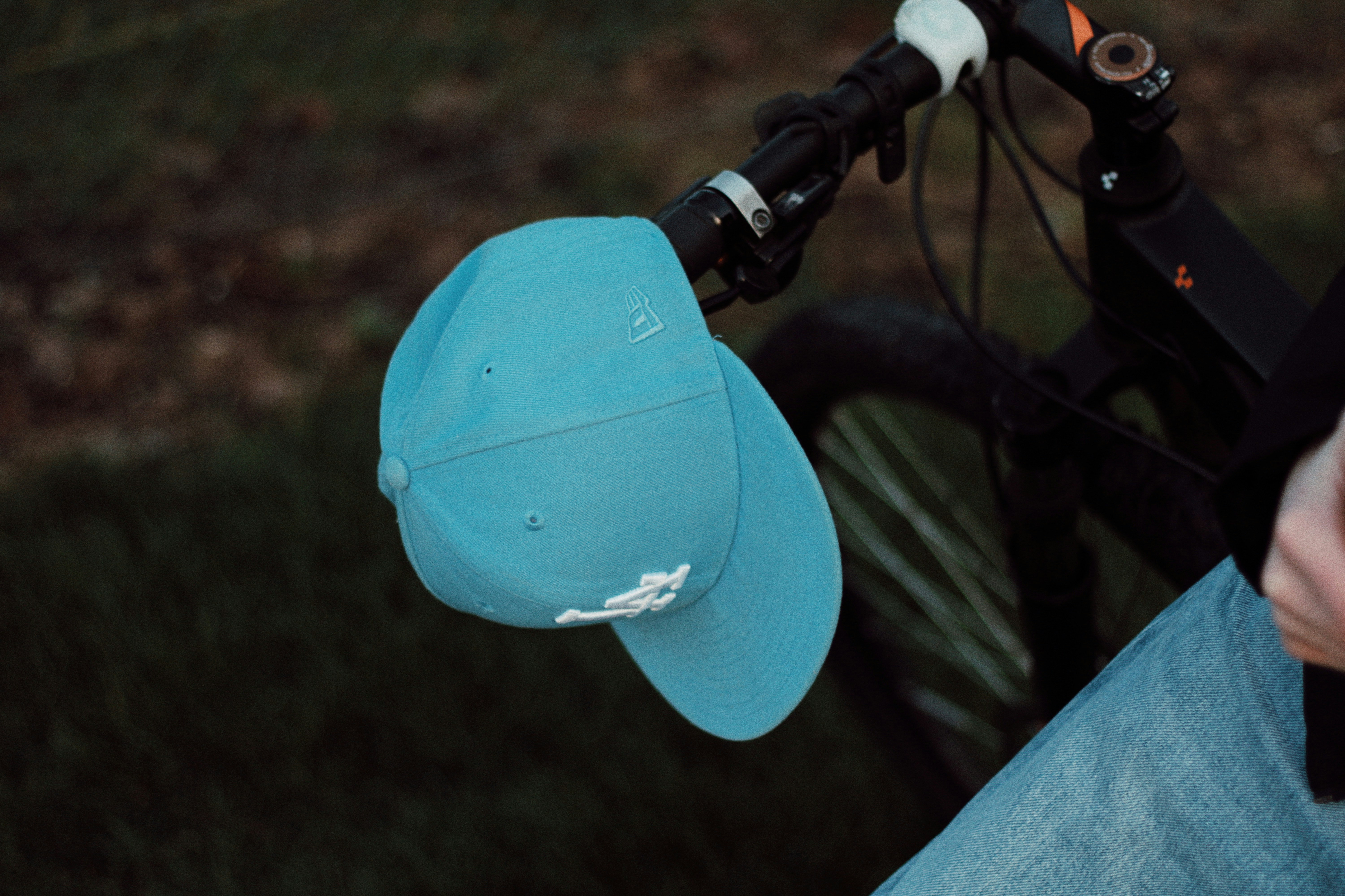 Blue cap on the bicycle handlebar: a moment of casual gear