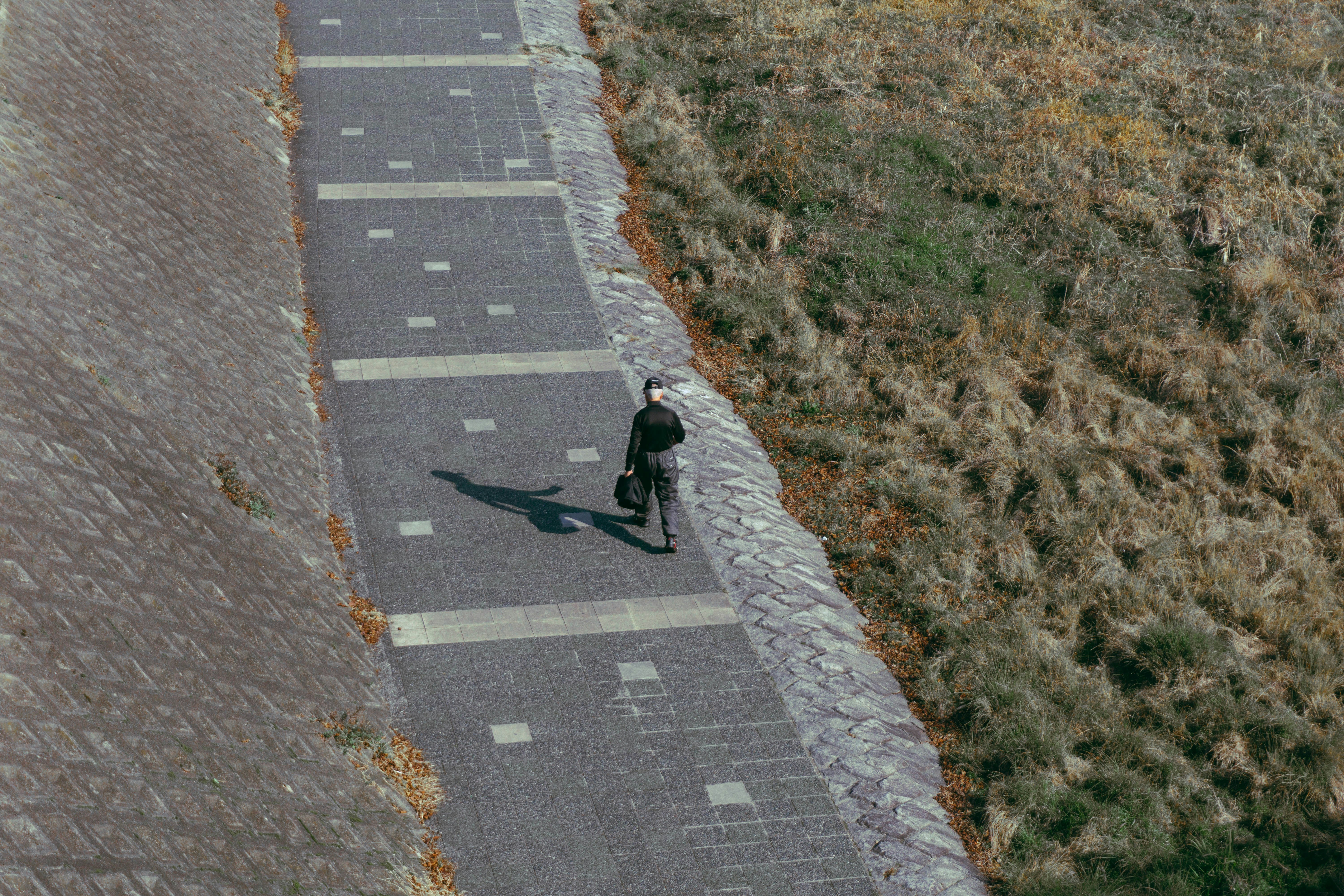 Solitary Wanderer on a Sloped, Stone-Paved Path