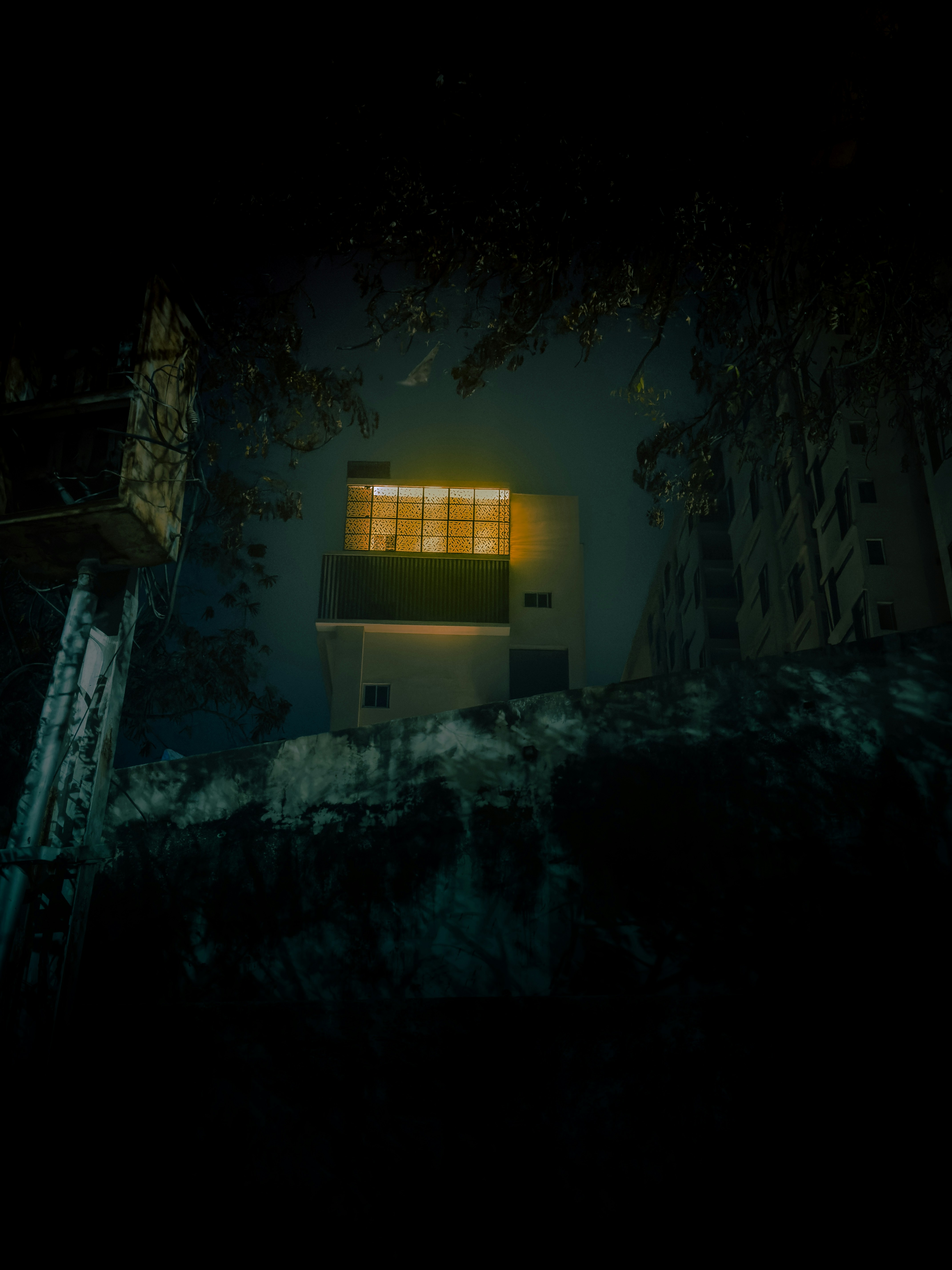 A building with a window lit up at night photo – Free Building Image on ...