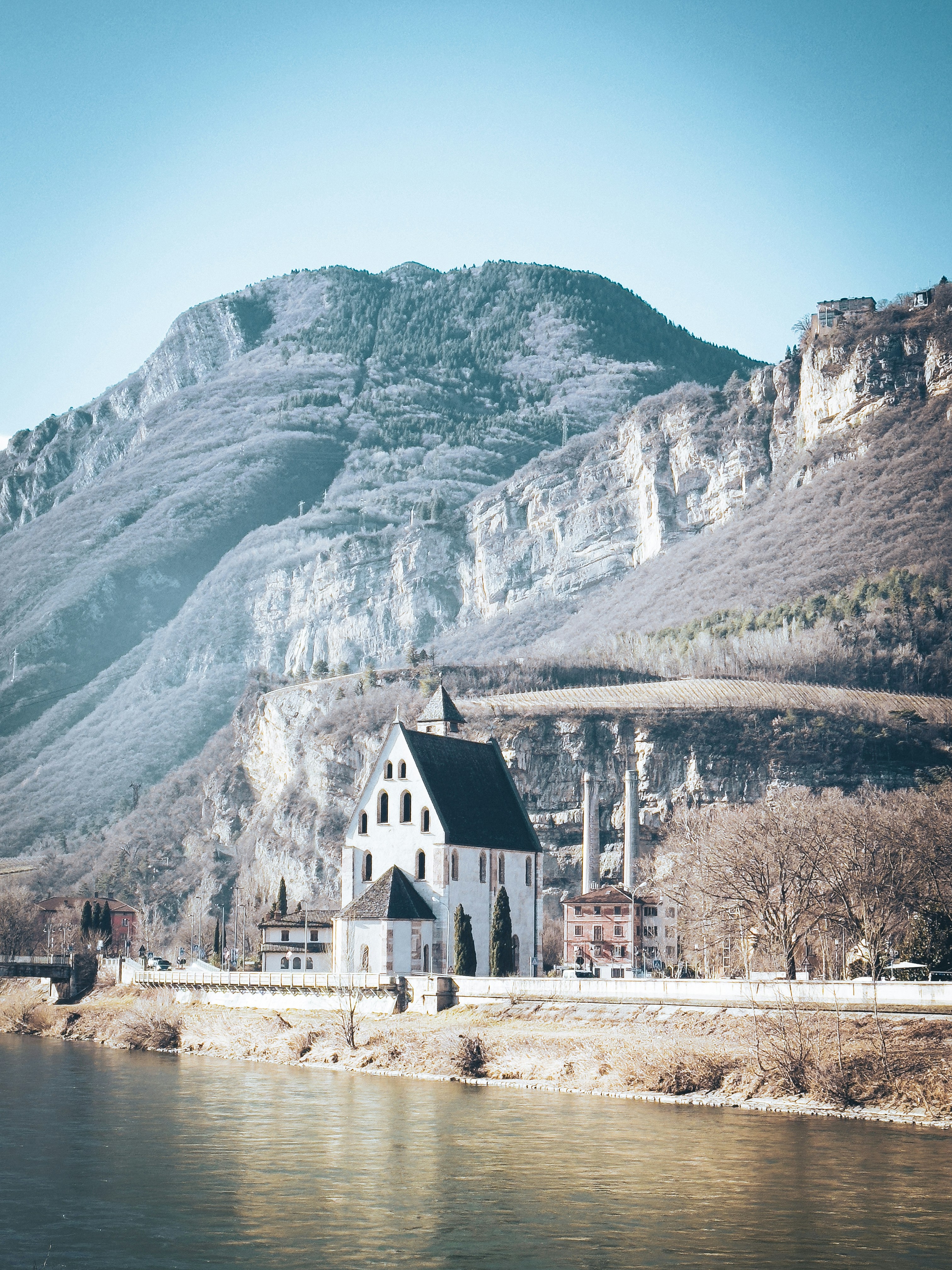 Riverside Chapel Between Stone Cliffs and Mountain Light