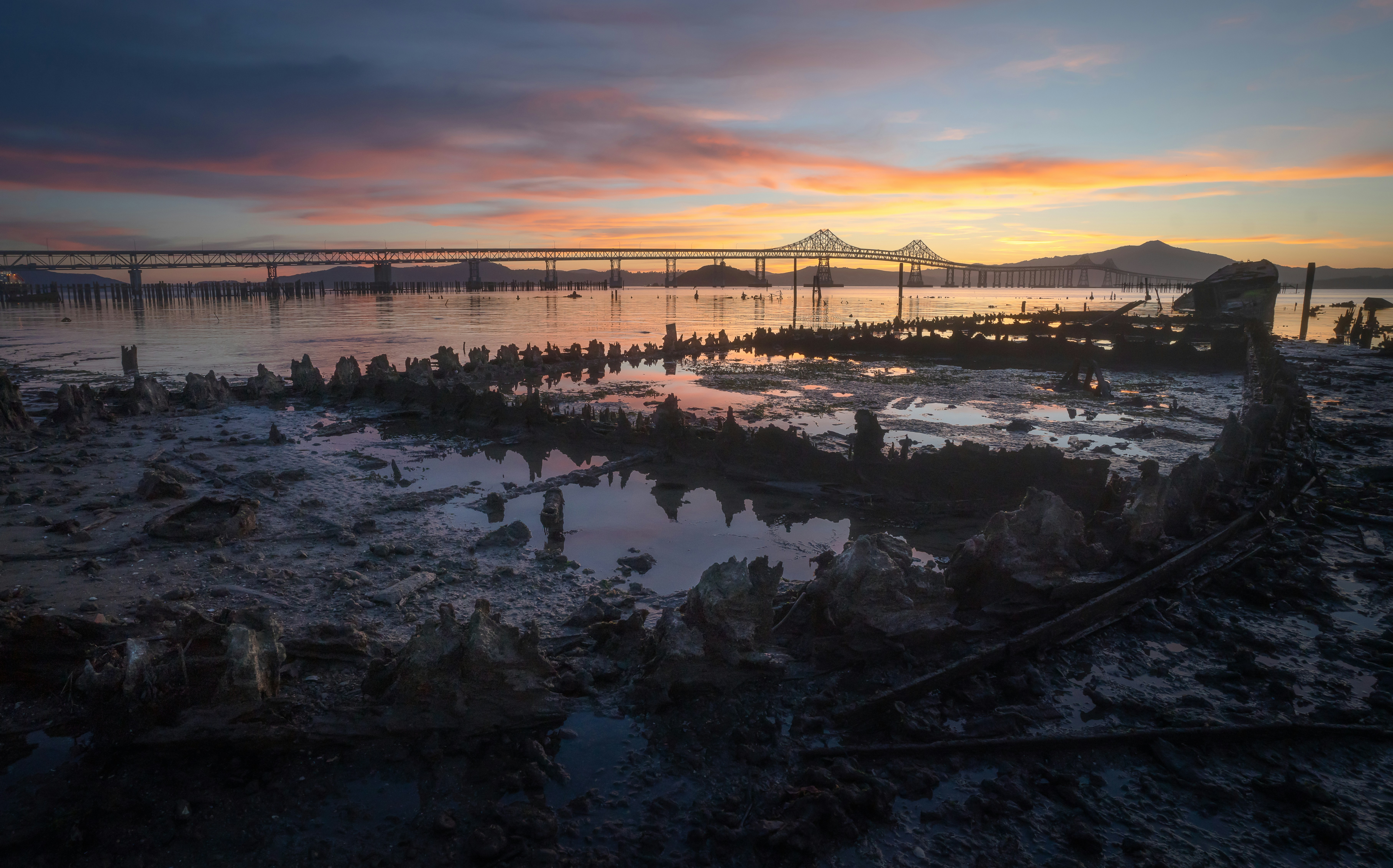 A large body of water with a bridge in the background photo – Free ...