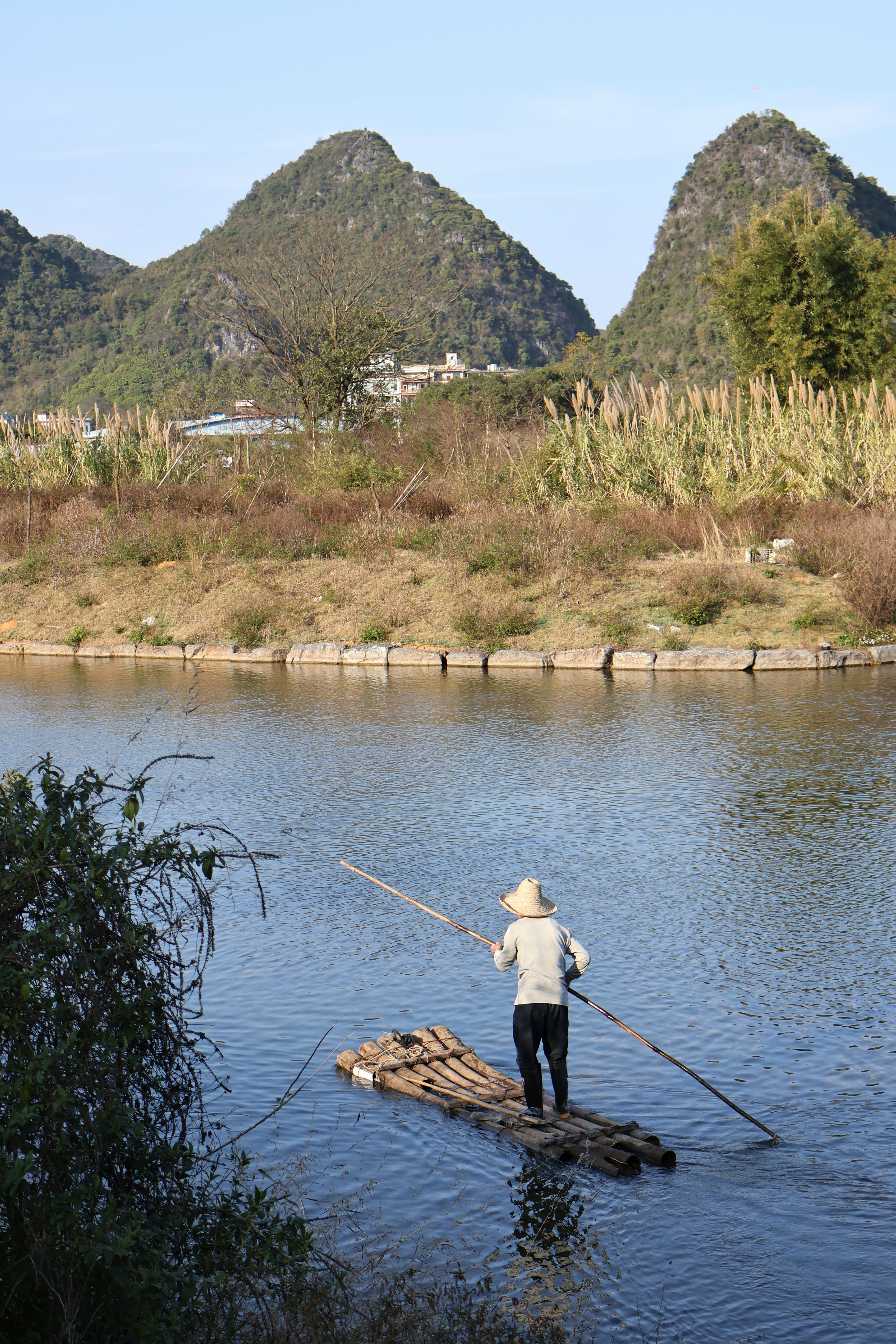 Bamboo-Raft Fisherman Beneath the Karst Peaks
