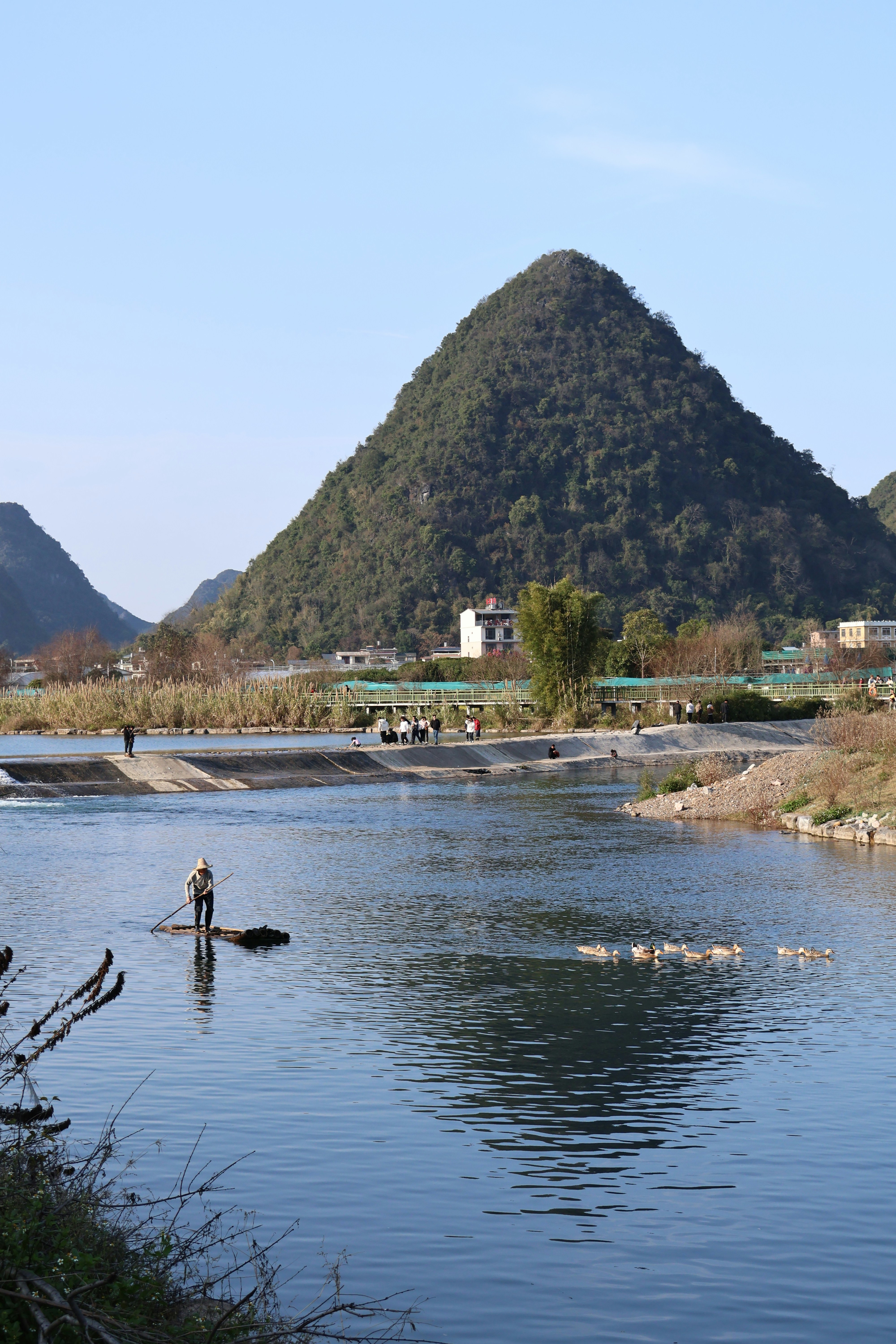 River Quietude: A Solo Paddleboarder Before the Verdant Peak