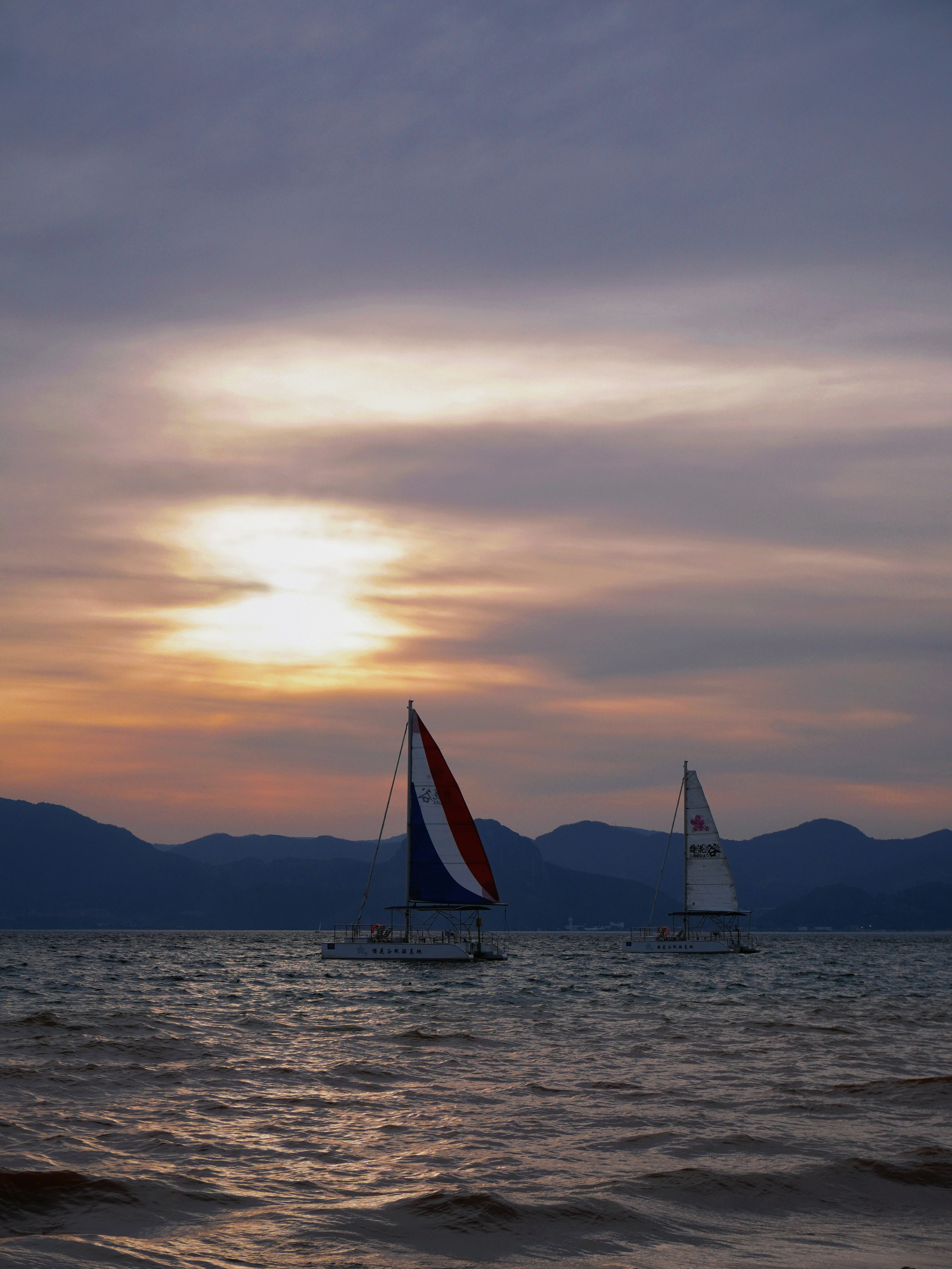 A couple of sail boats floating on top of a body of water photo – Free ...