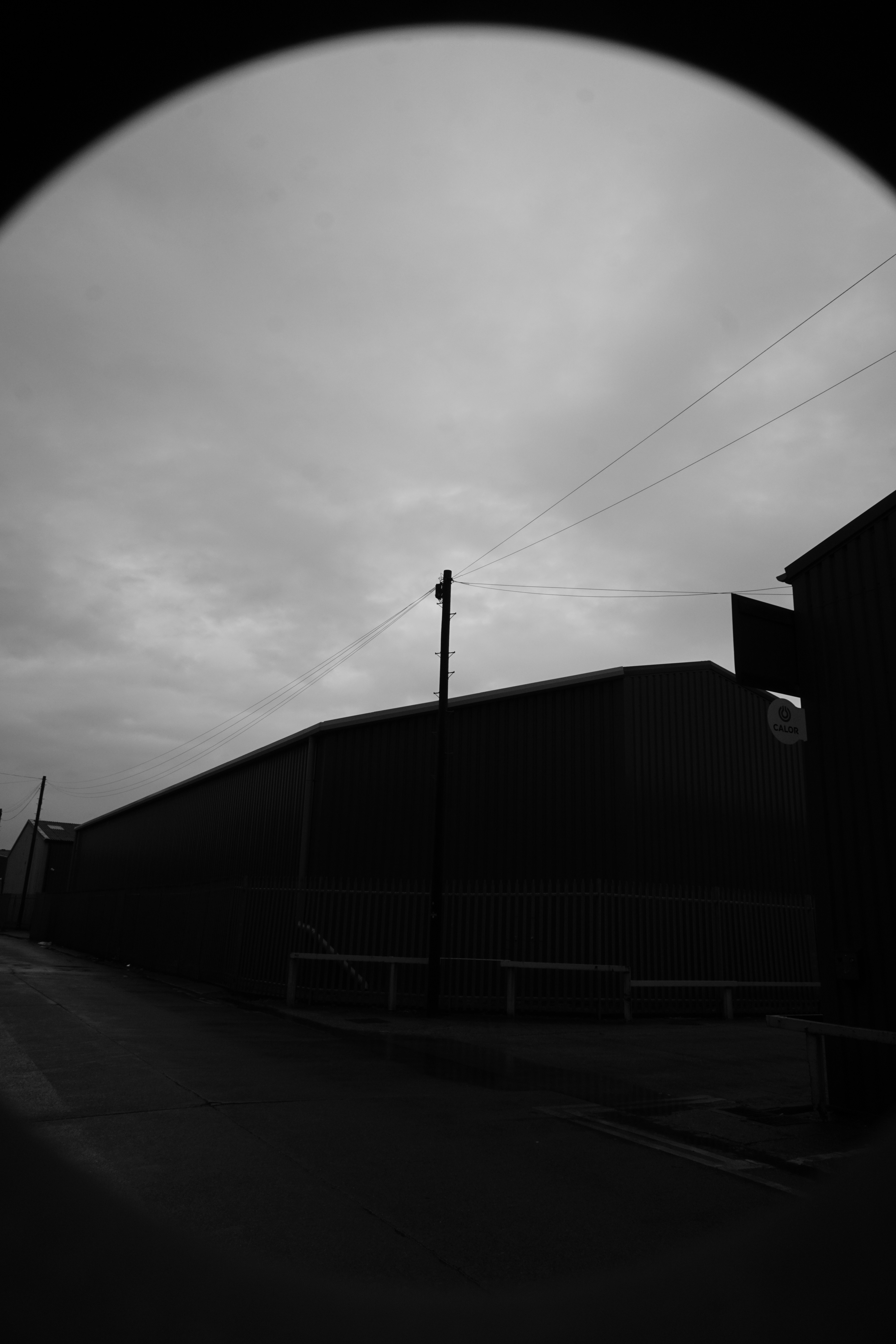Monochrome Spine: Power Lines Crossing a Silent Warehouse