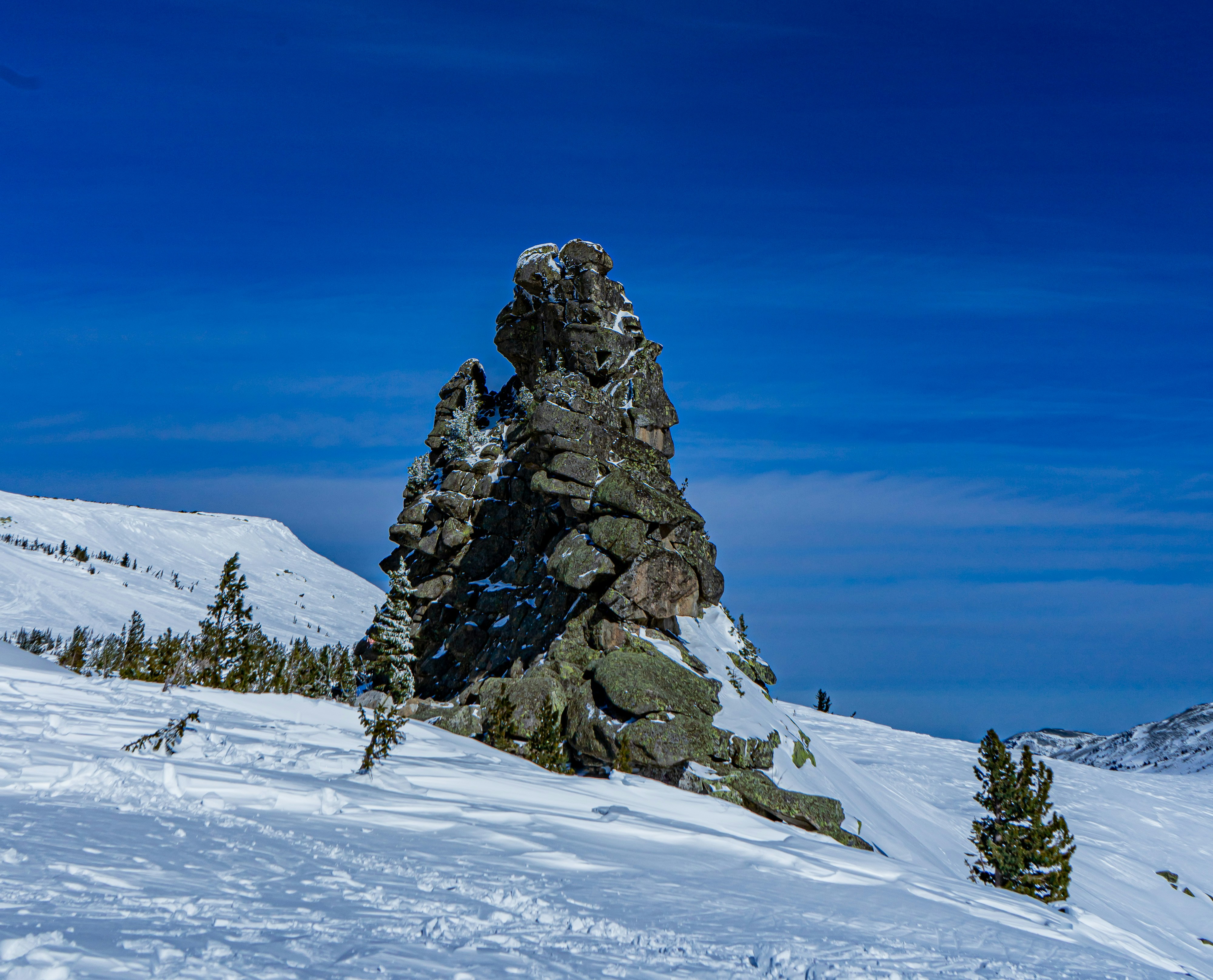 The Snowbound Sentinel: A Granite Monolith Rising Over Frosted Slopes