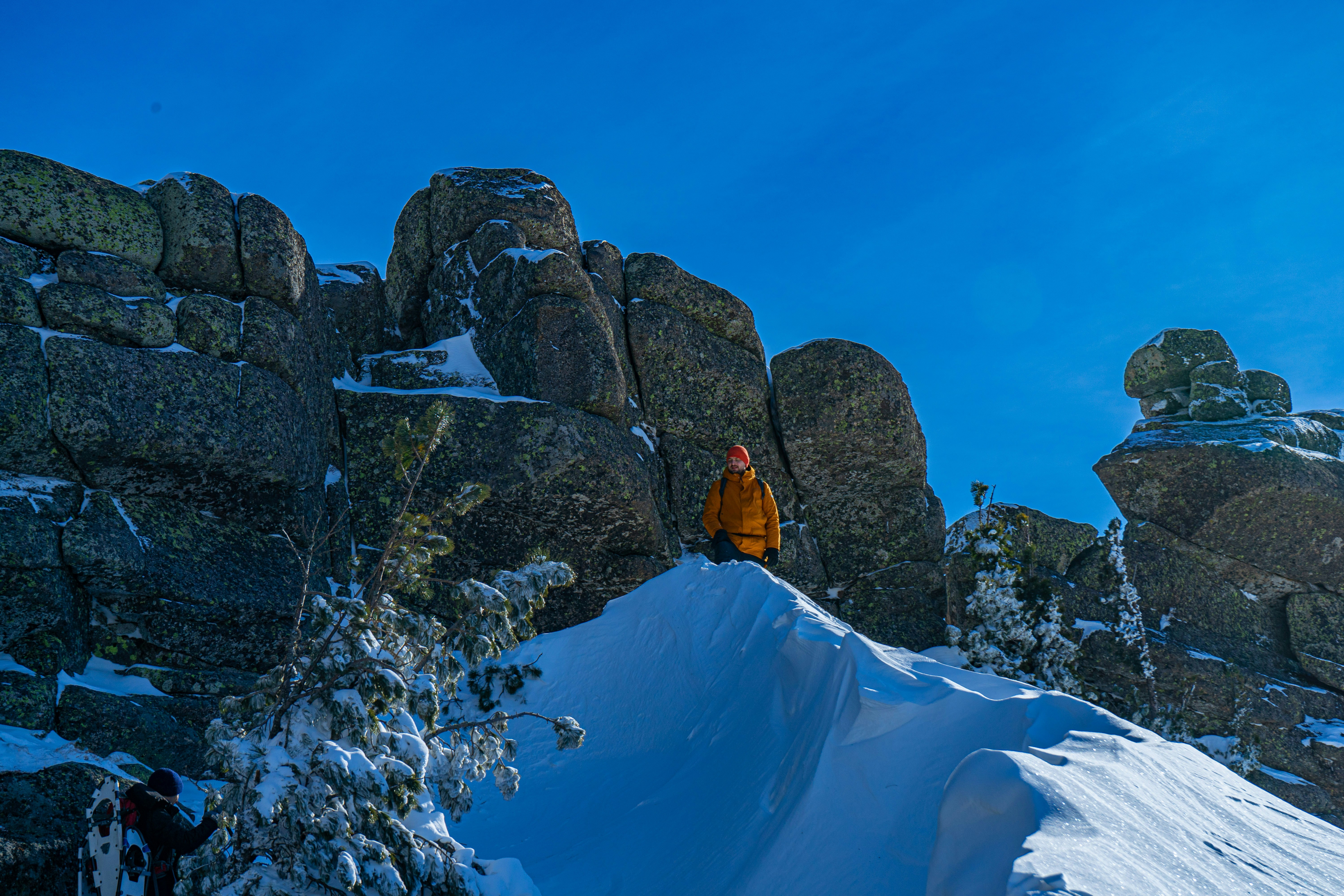 Summit Solitude: A Lone Explorer Amidst Snowy Peaks