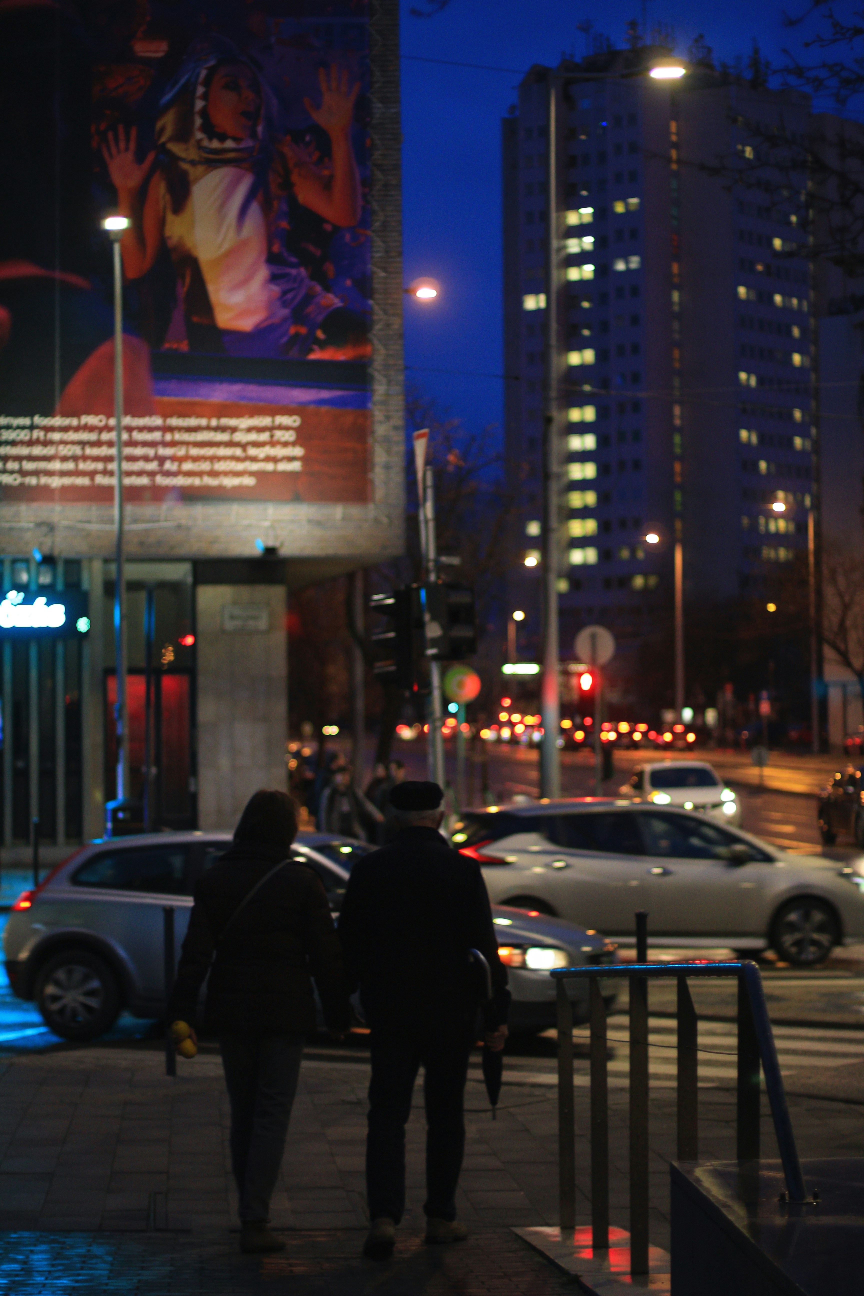 Night Crossing: Pedestrians Enter the City Pulse Under Neon Billboards