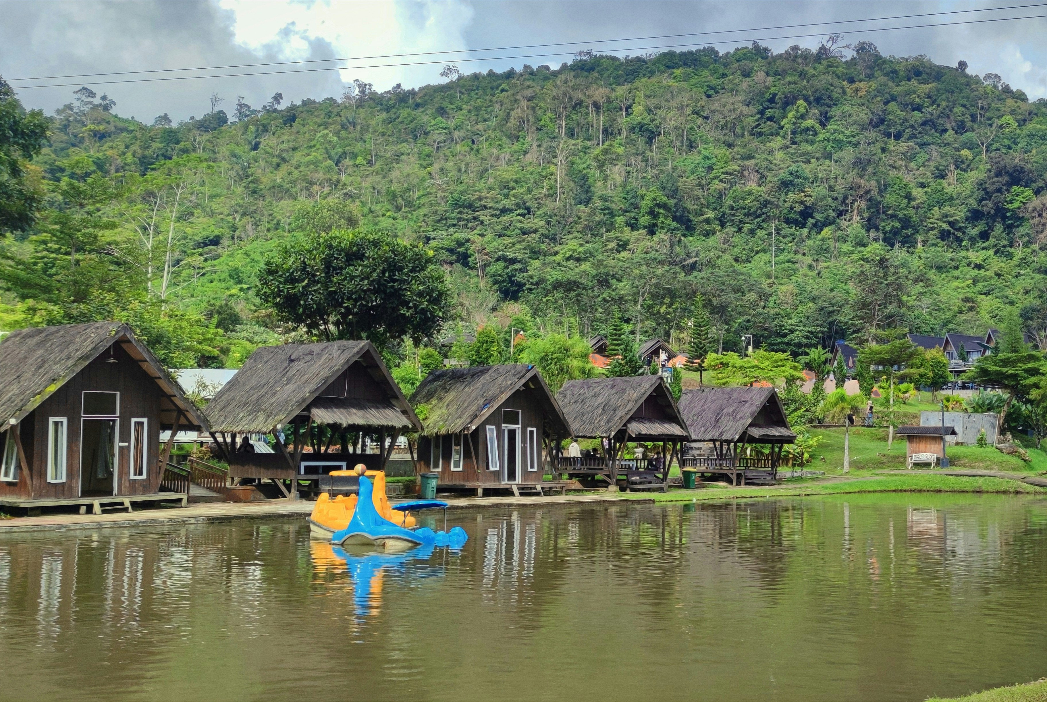 A row of huts sitting on top of a lake photo – Free Wisata Image on ...