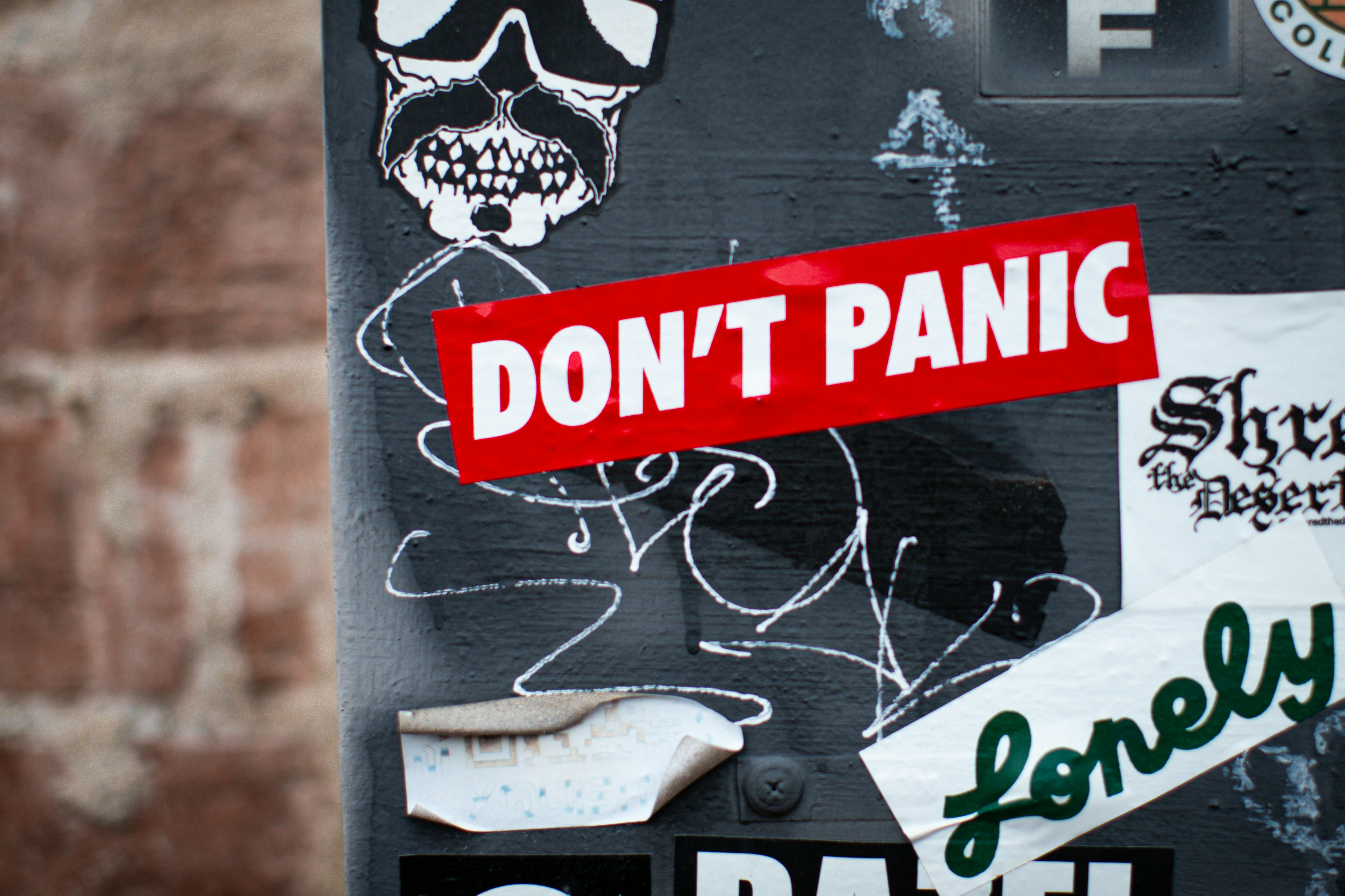 A sign with stickers on it that says don't panic photo – Free Red Image ...