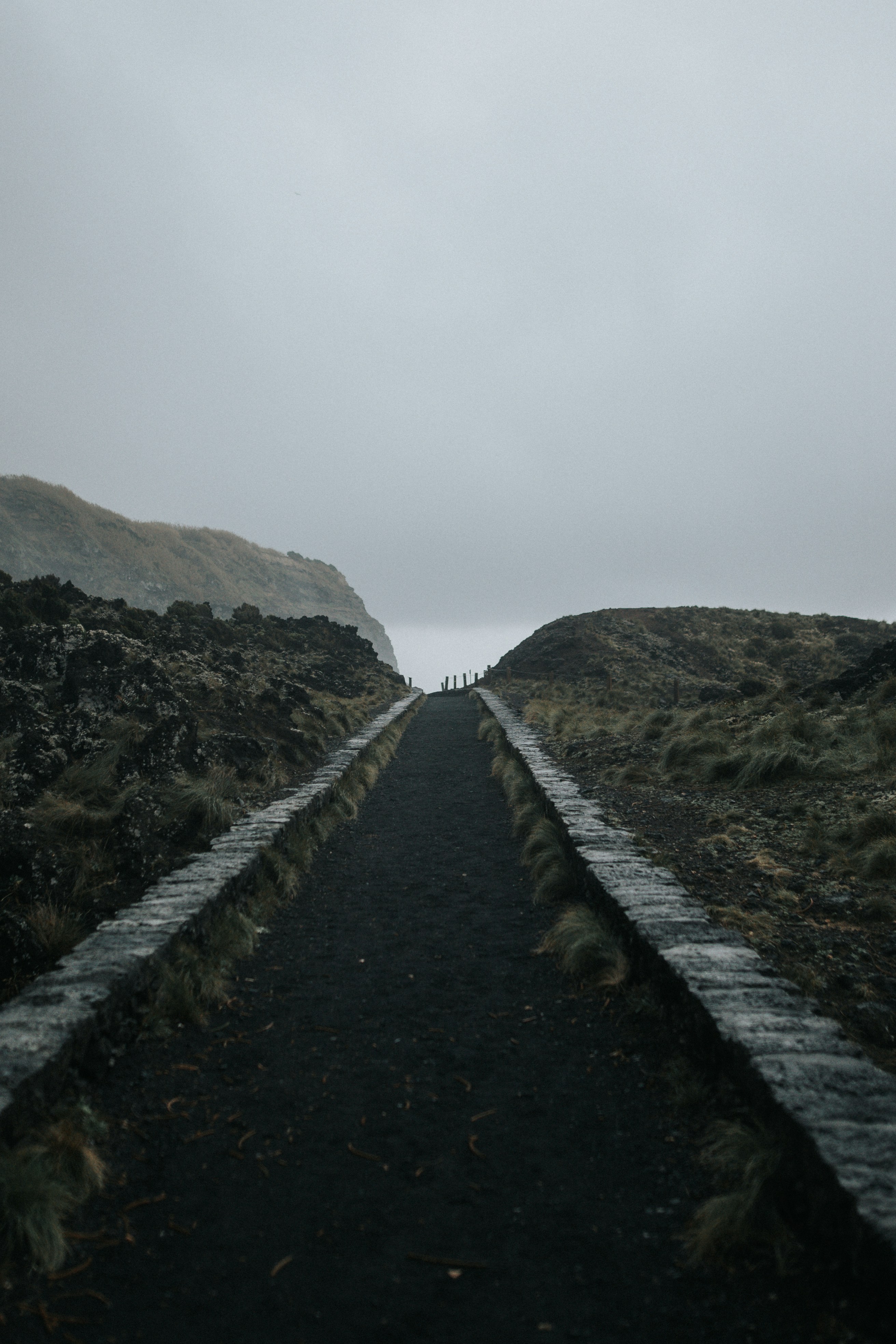 Converging Coastal Path Toward a Fog-Washed Horizon