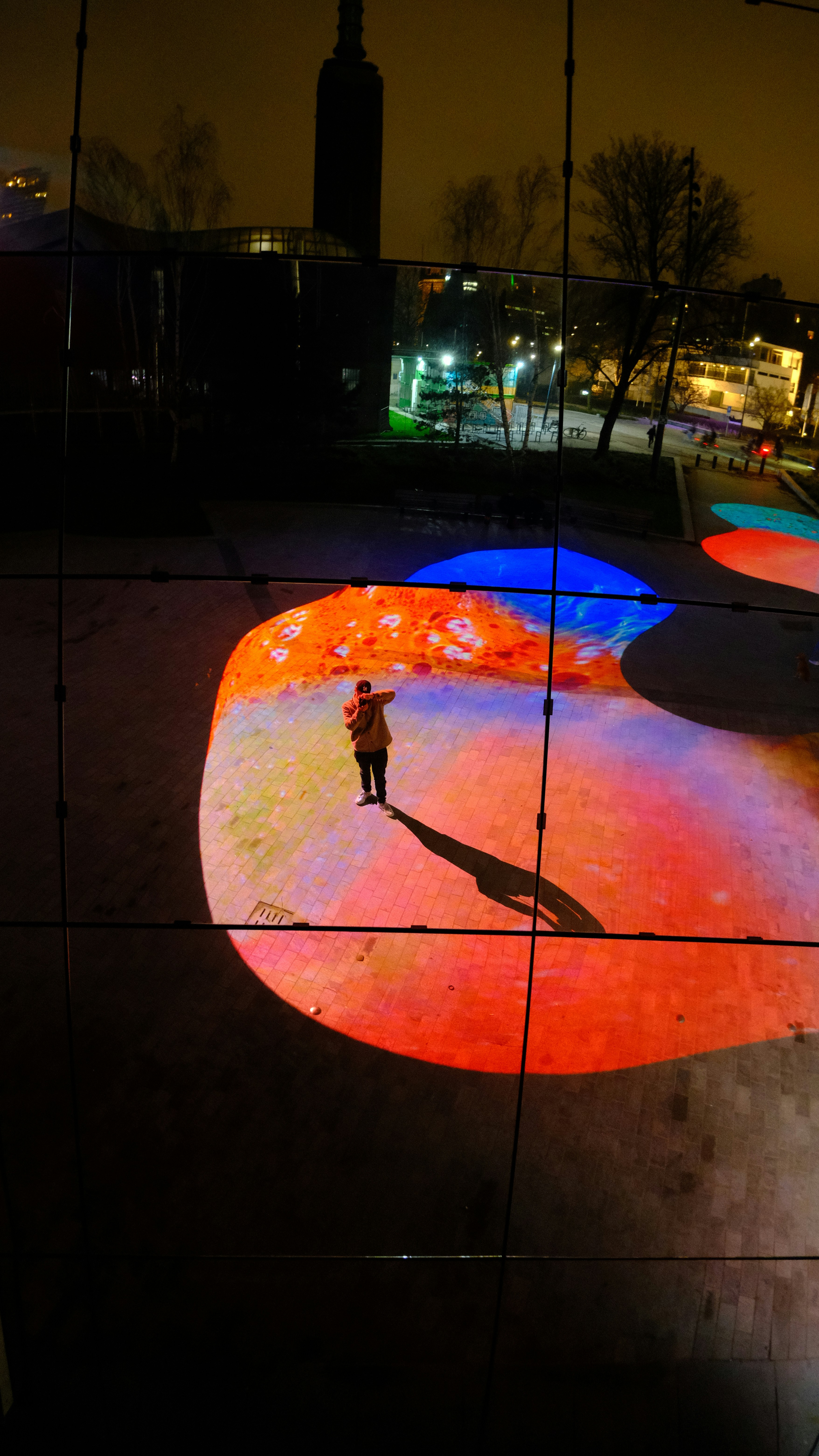 Kaleidoscopic Circle on a Night Plaza: A Lone Figure
