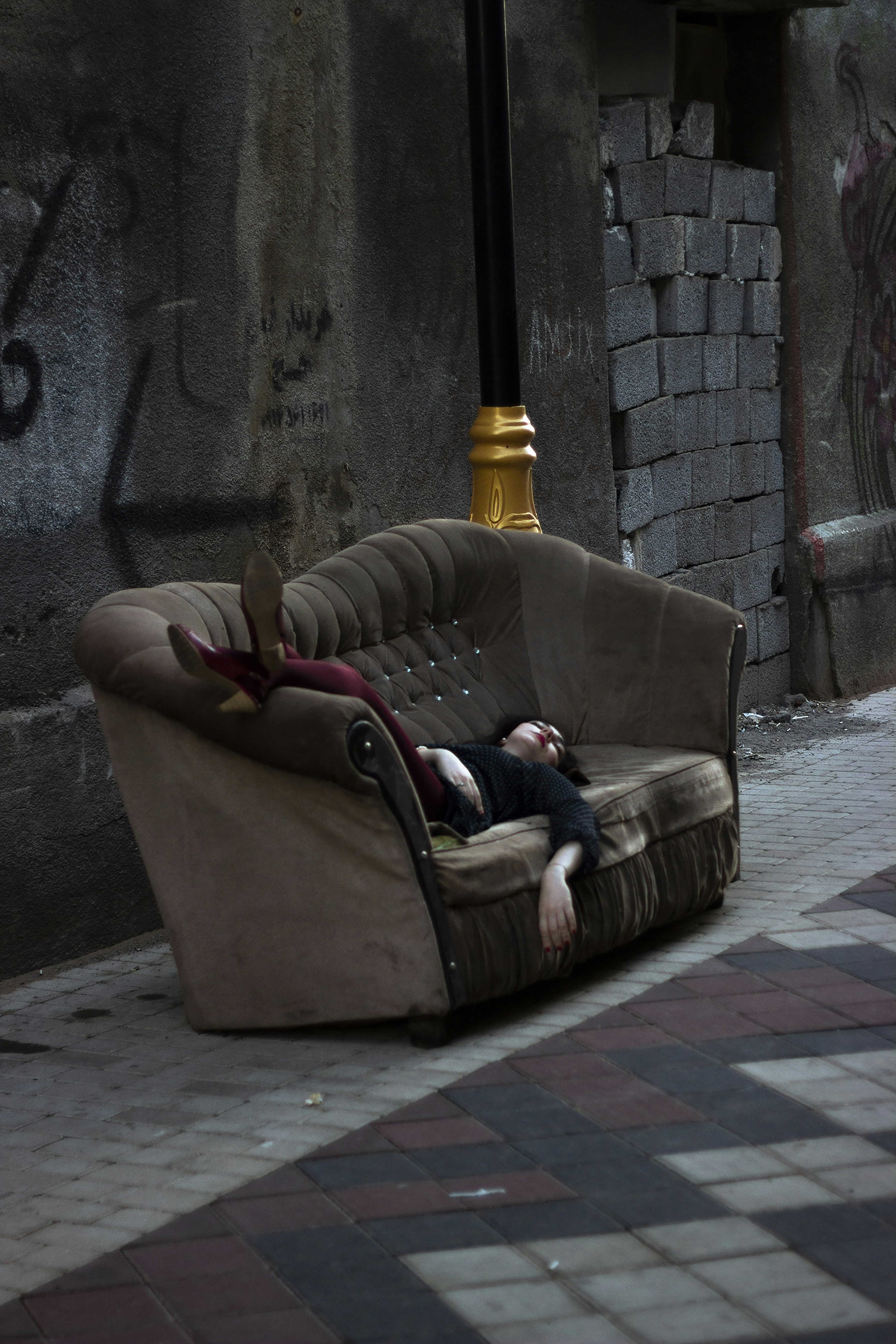 A man laying on top of a couch on a sidewalk photo – Free Tabriz Image ...
