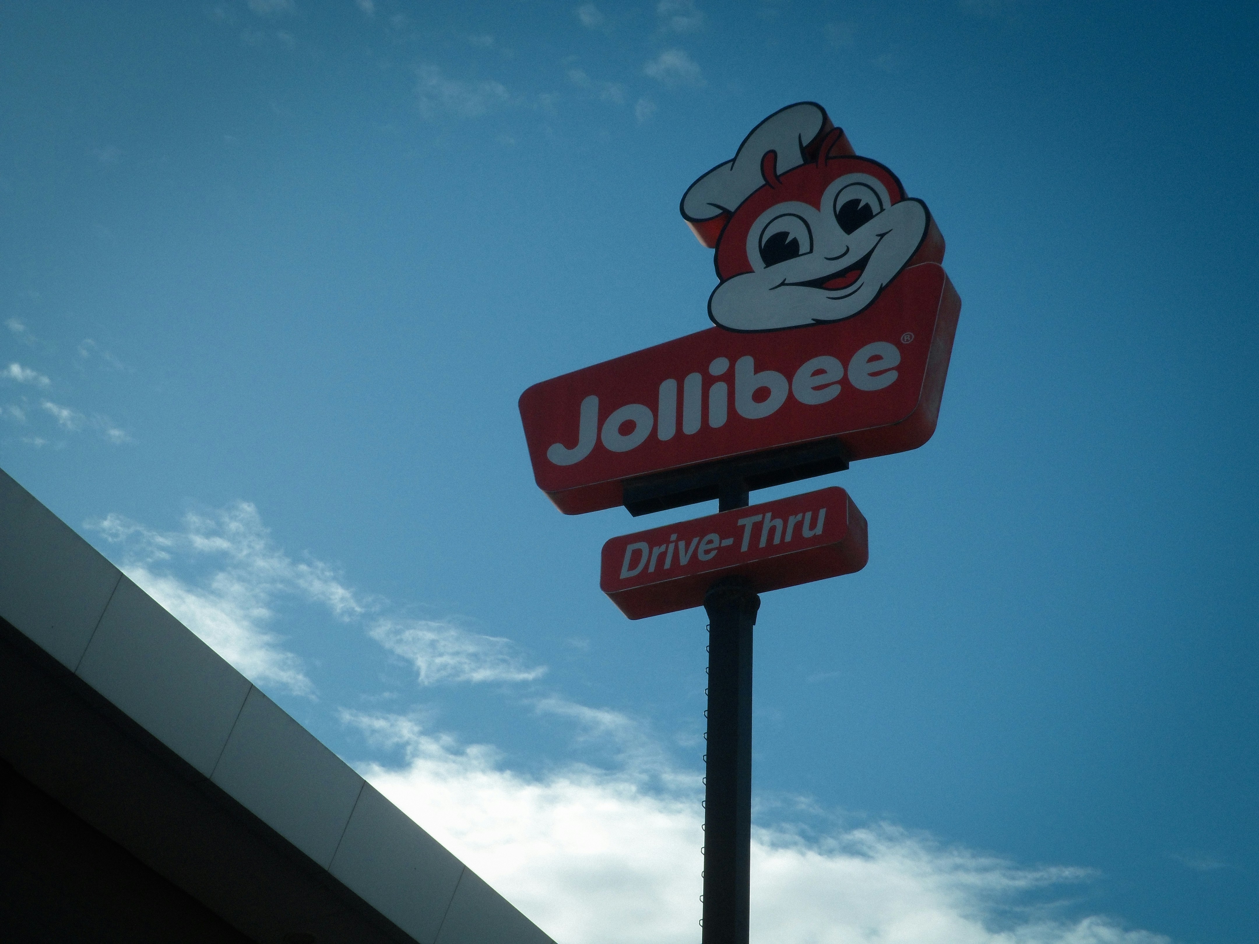 A jollibee drive thru sign with a sky background photo – Free Blue ...