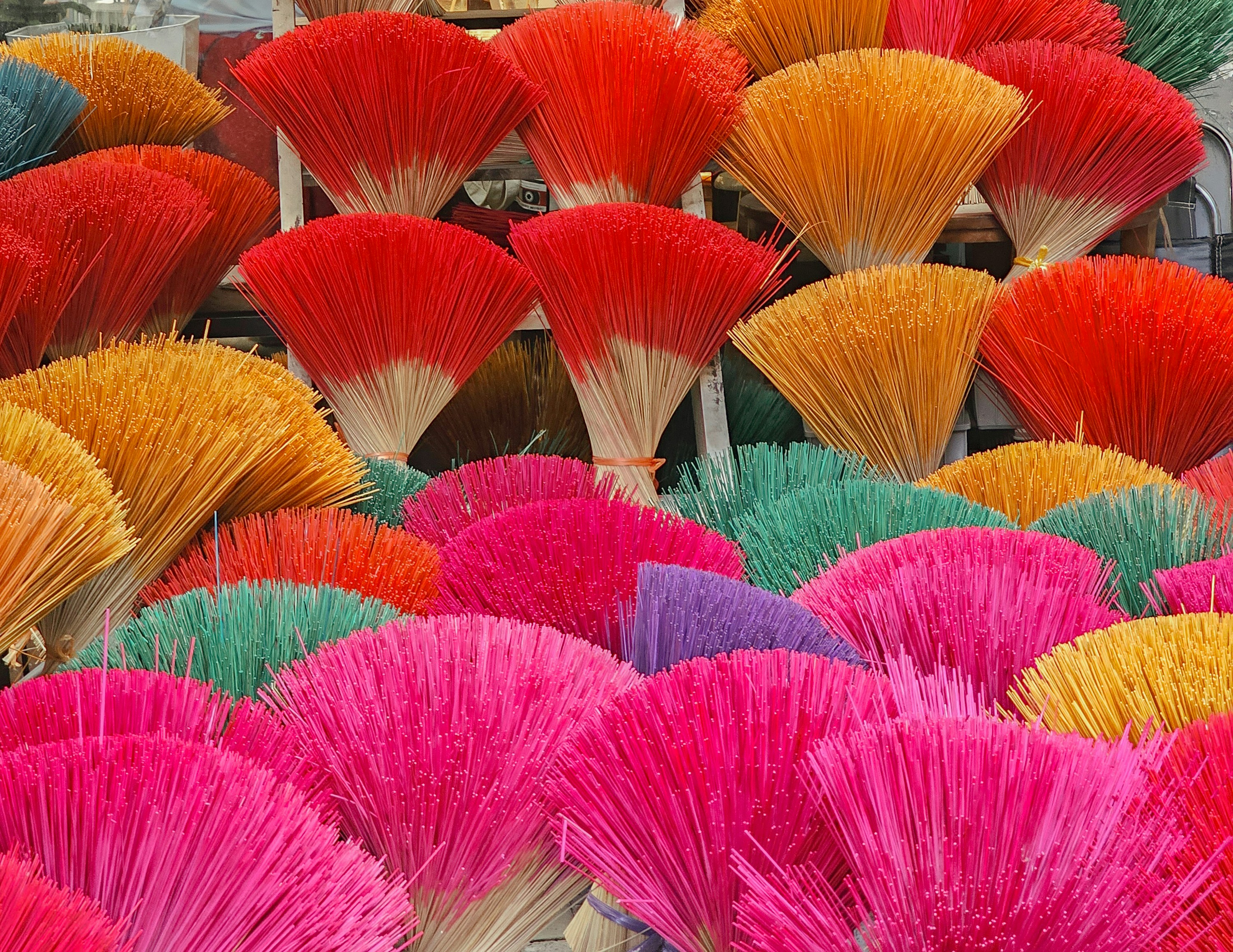 Concentric Bristle Parade: A Storefront Rainbow of Colorful Brooms