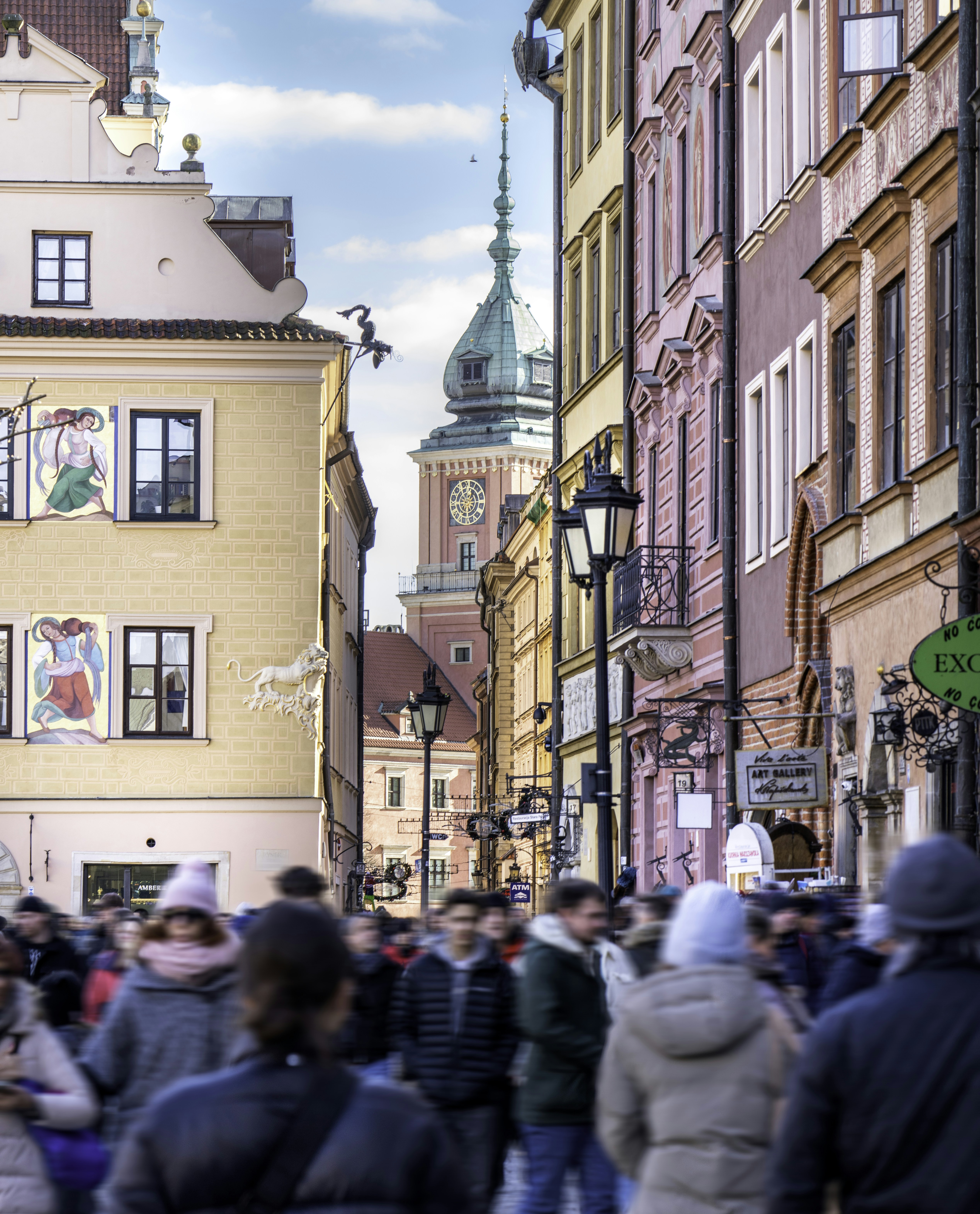 A crowd of people walking down a street next to tall buildings photo ...