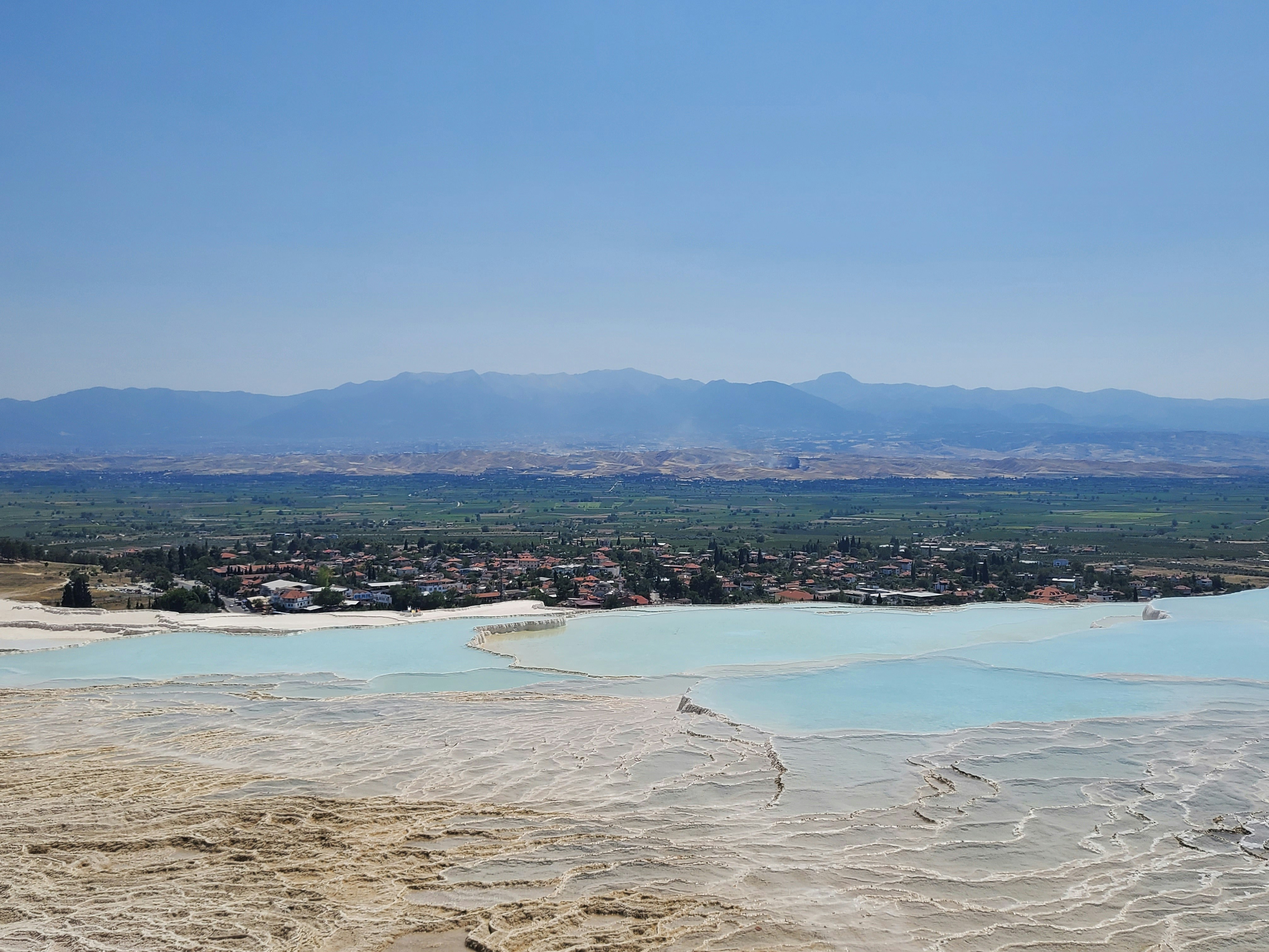 A view from Pamukkale springs | a large body of water with mountains in the background