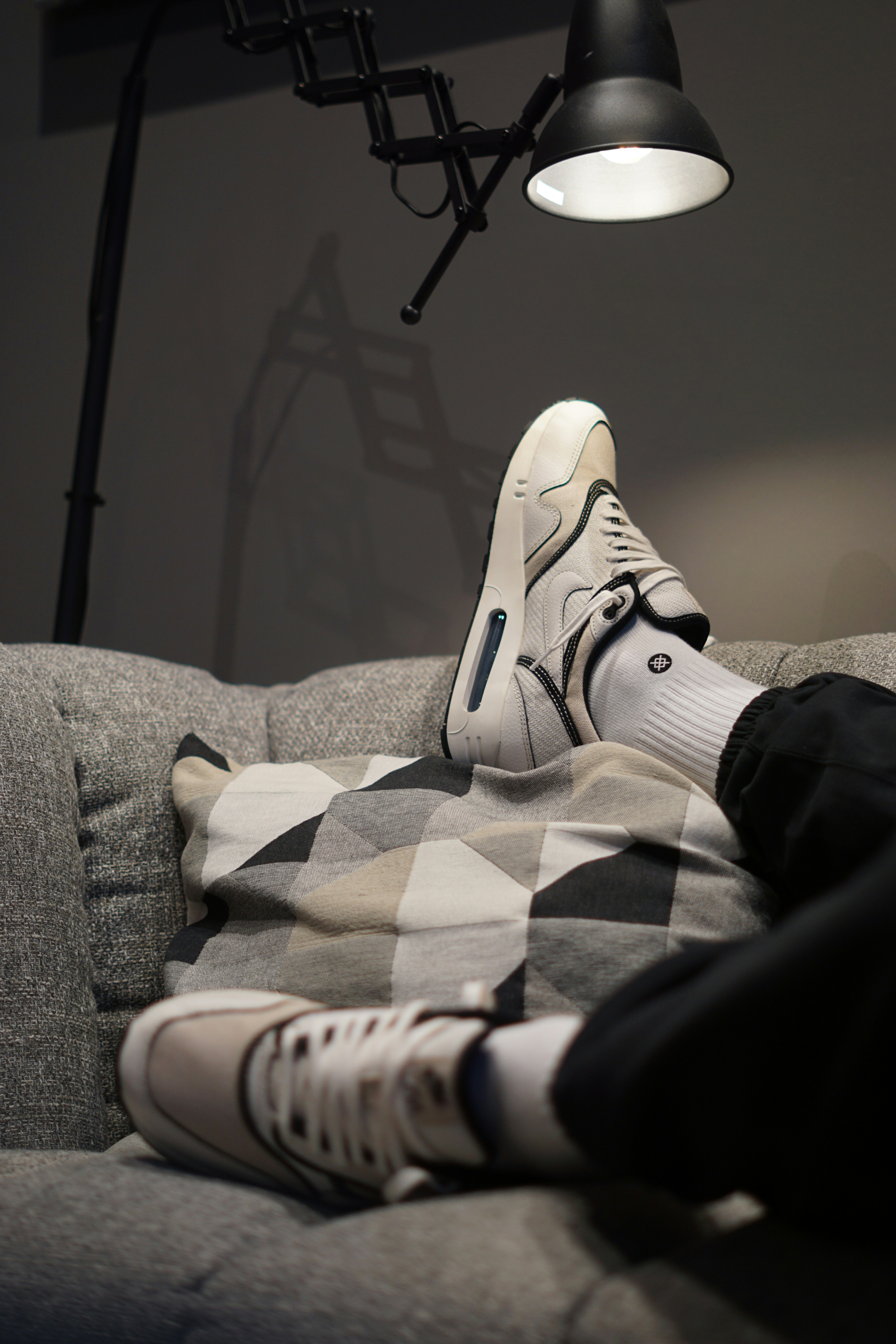 Una persona acostada en un sofá con los pies en alto foto – Imagen de ...